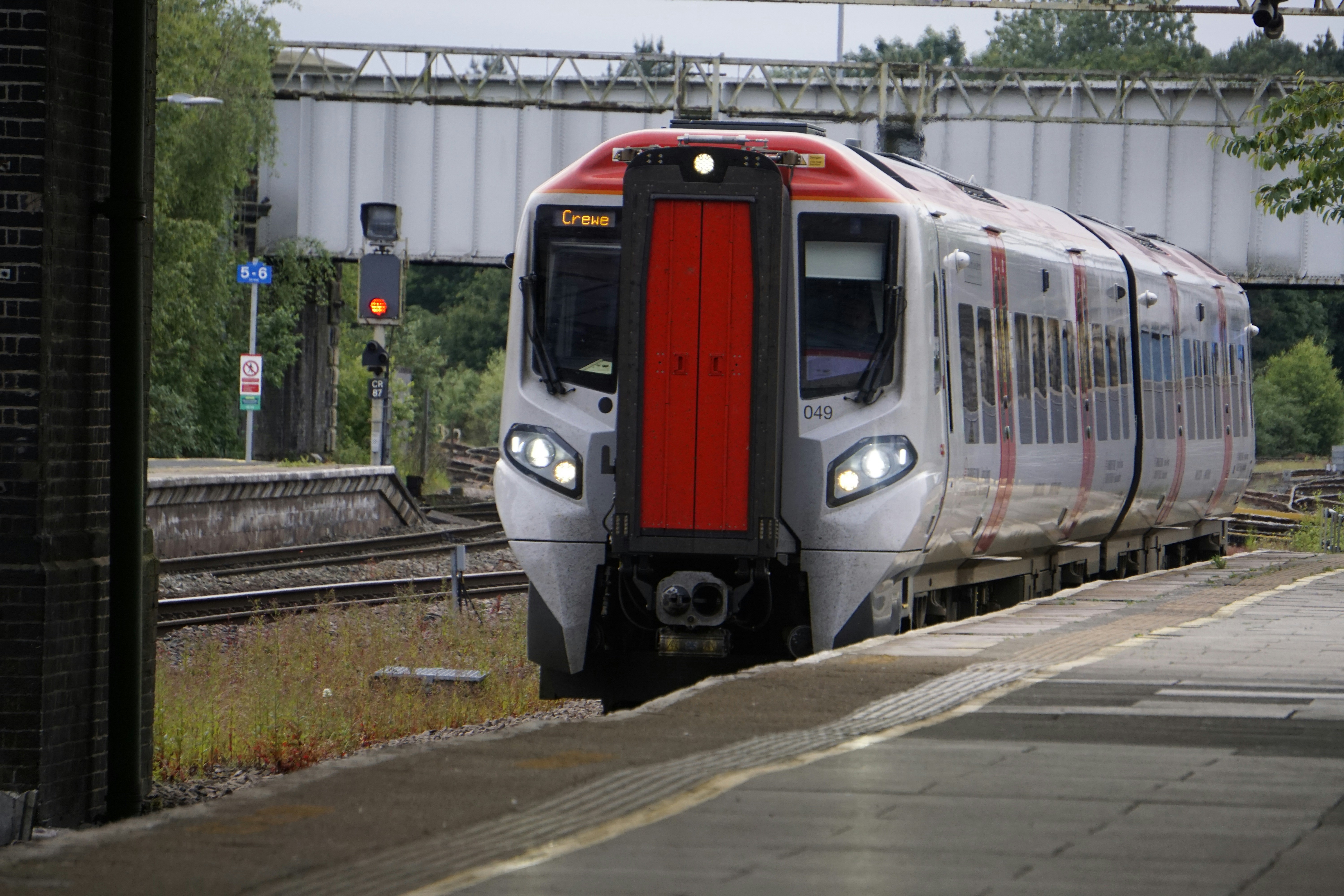 A train traveling down tracks next to a train station photo – Free ...