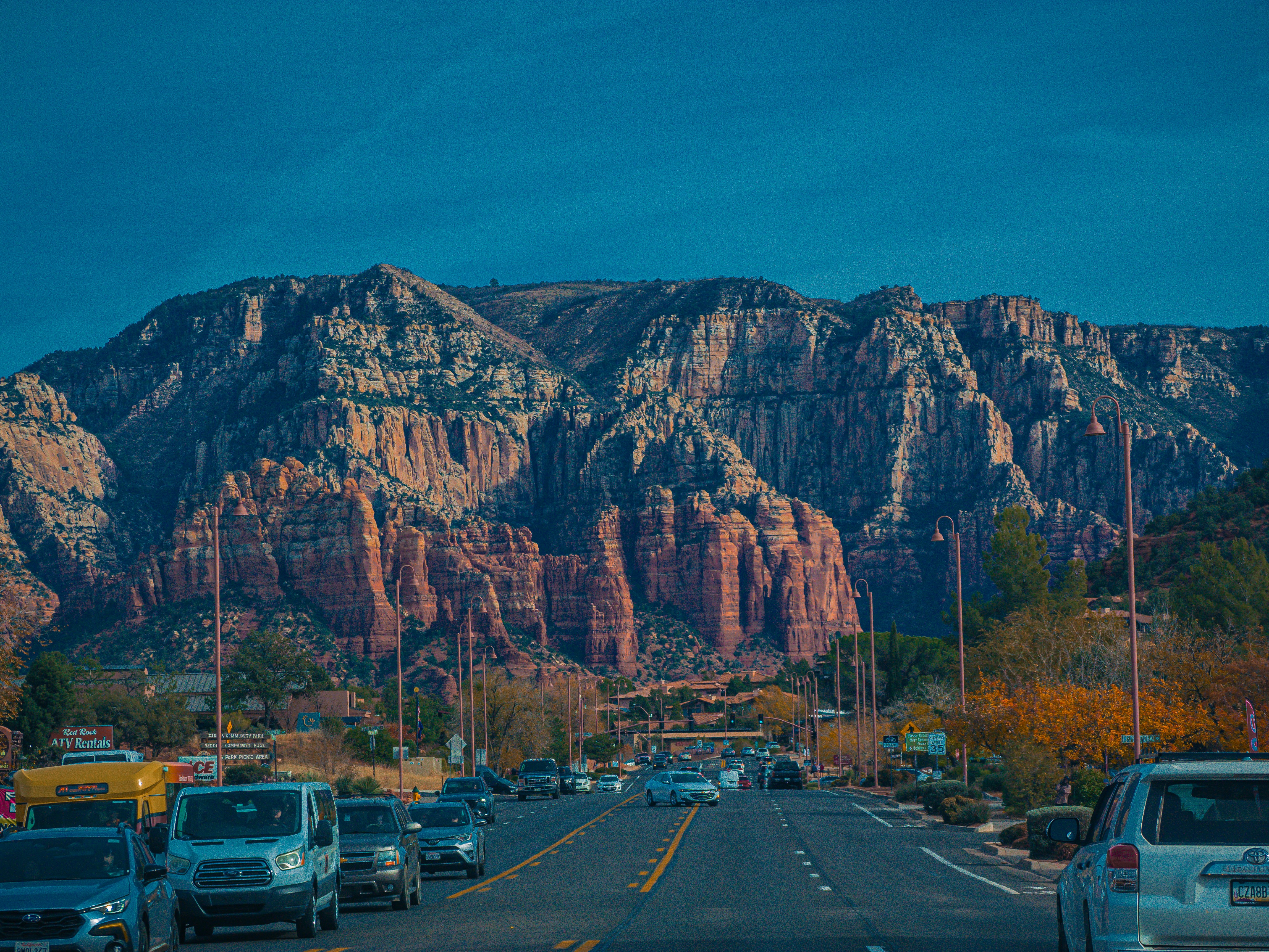 Rush Hour at the Red Cliffs: Vehicles Converge on the Desert Wall