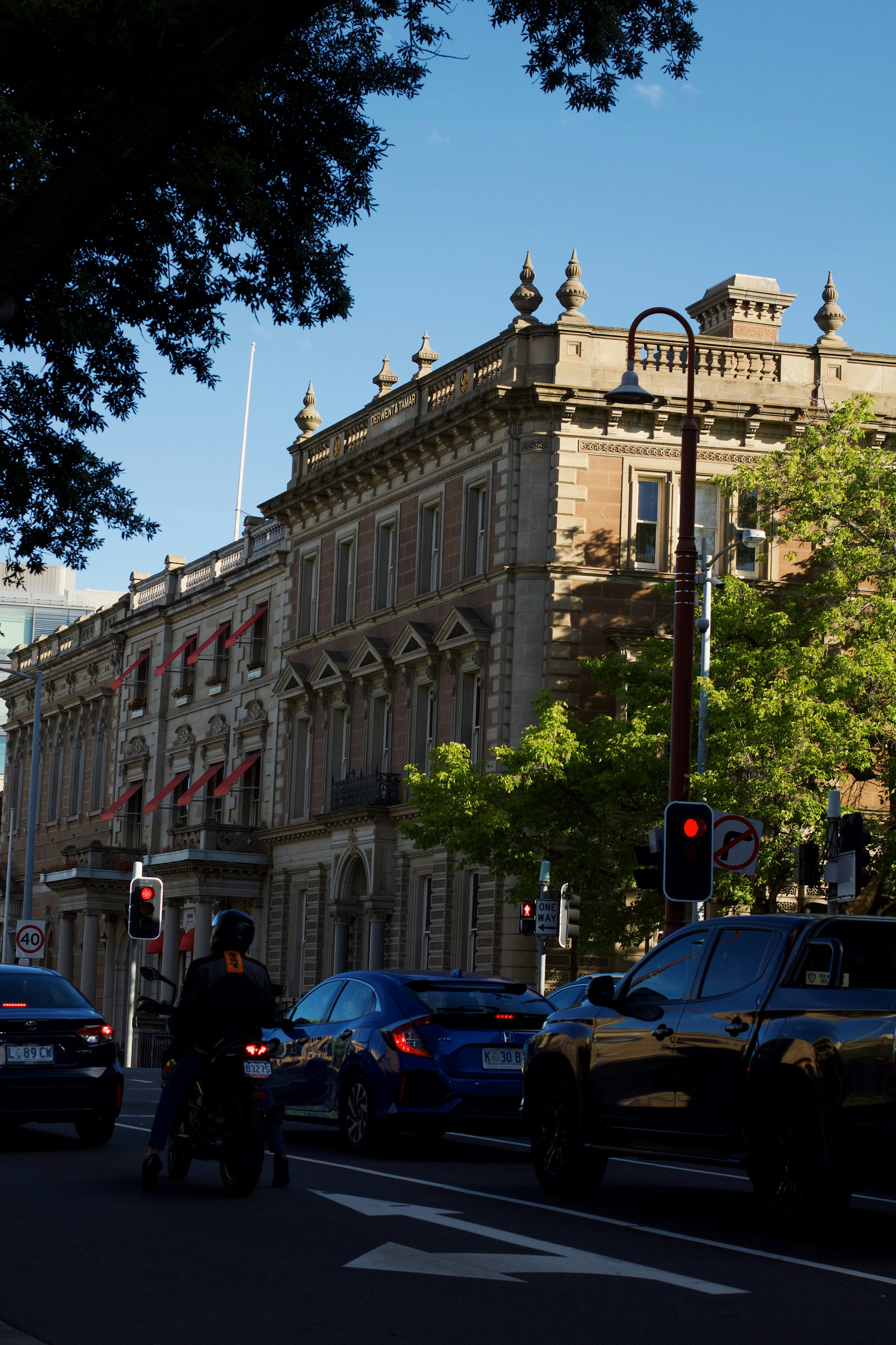 A man riding a bike down a street next to tall buildings photo – Free ...