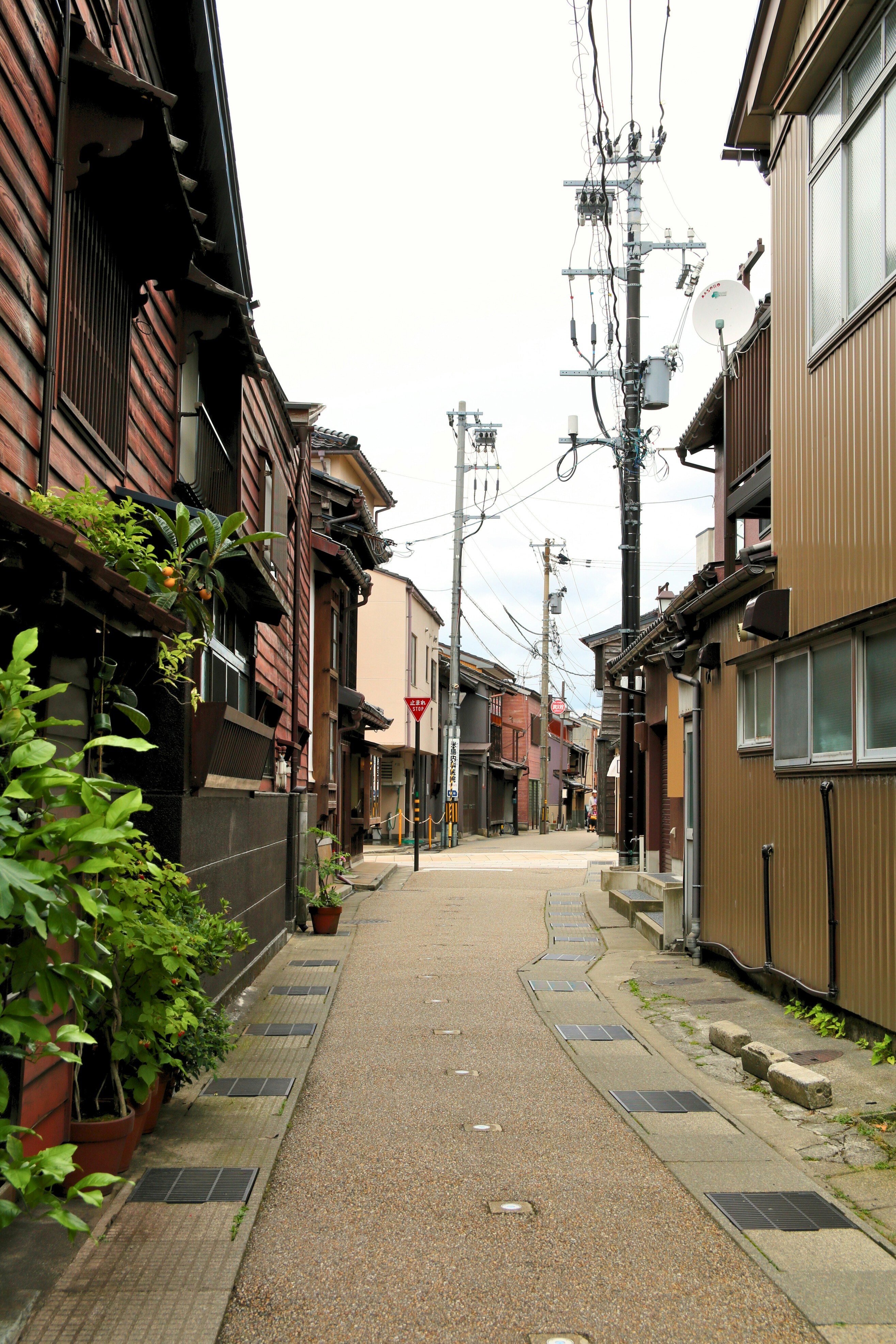 A narrow city street lined with wooden buildings photo – Free Kanazawa ...