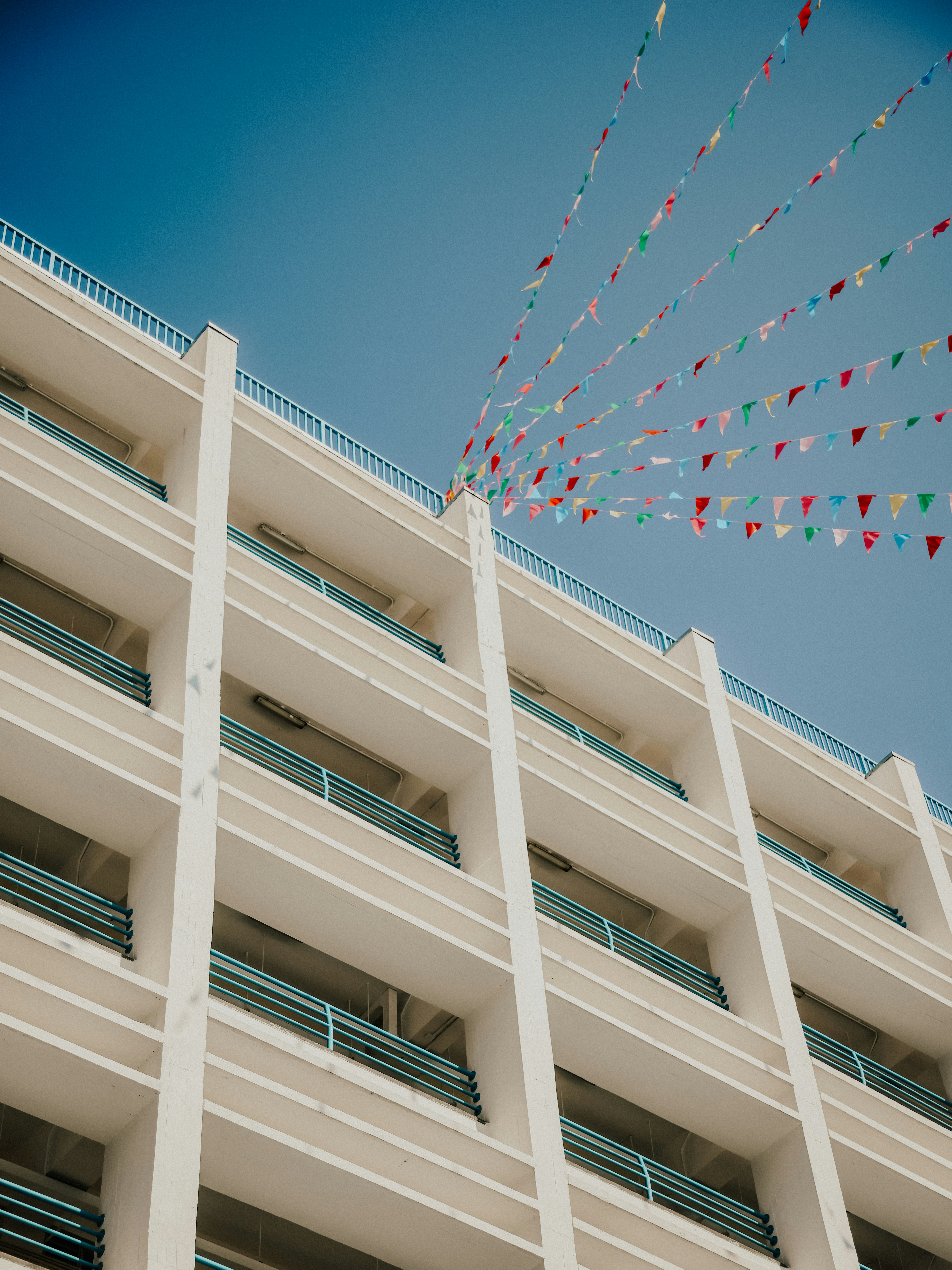 A tall white building with balconies and a kite flying in the air photo ...