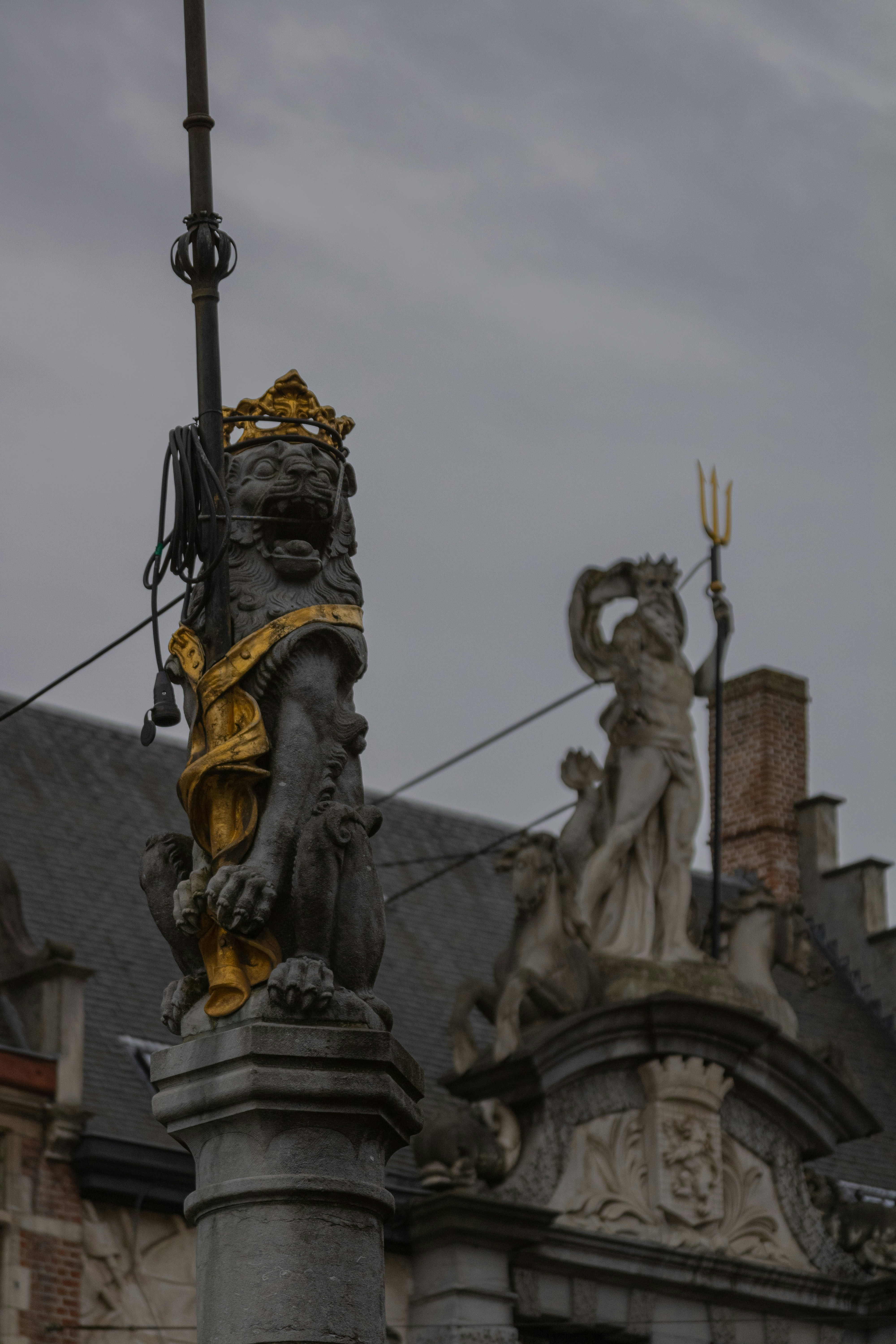 Gilded Sentinel: Stone Guardian under a Slate Sky in the Historic Plaza