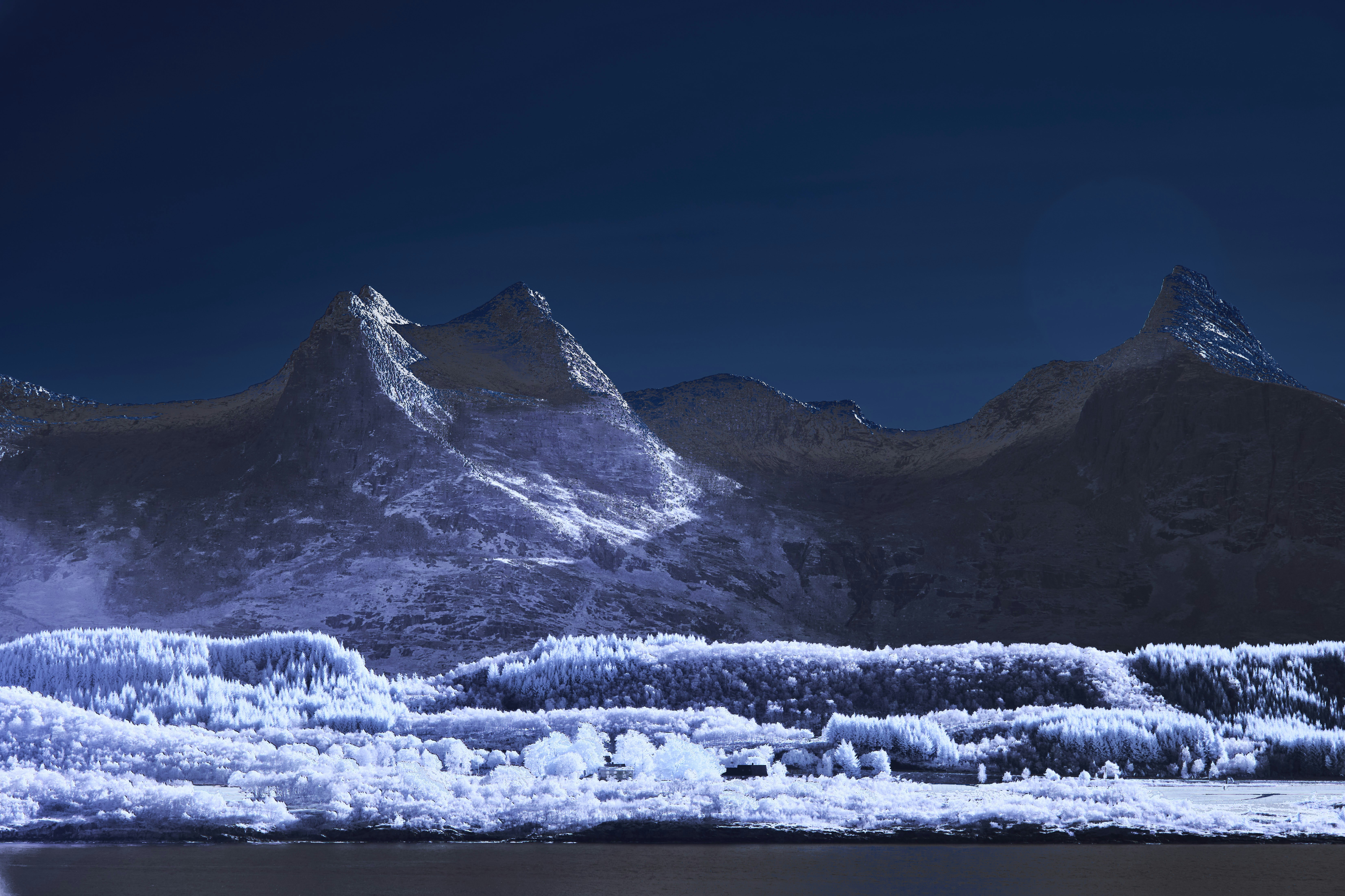 Cobalt Crest: Frosted Peaks Above a Glassy Ice-Blue Shore