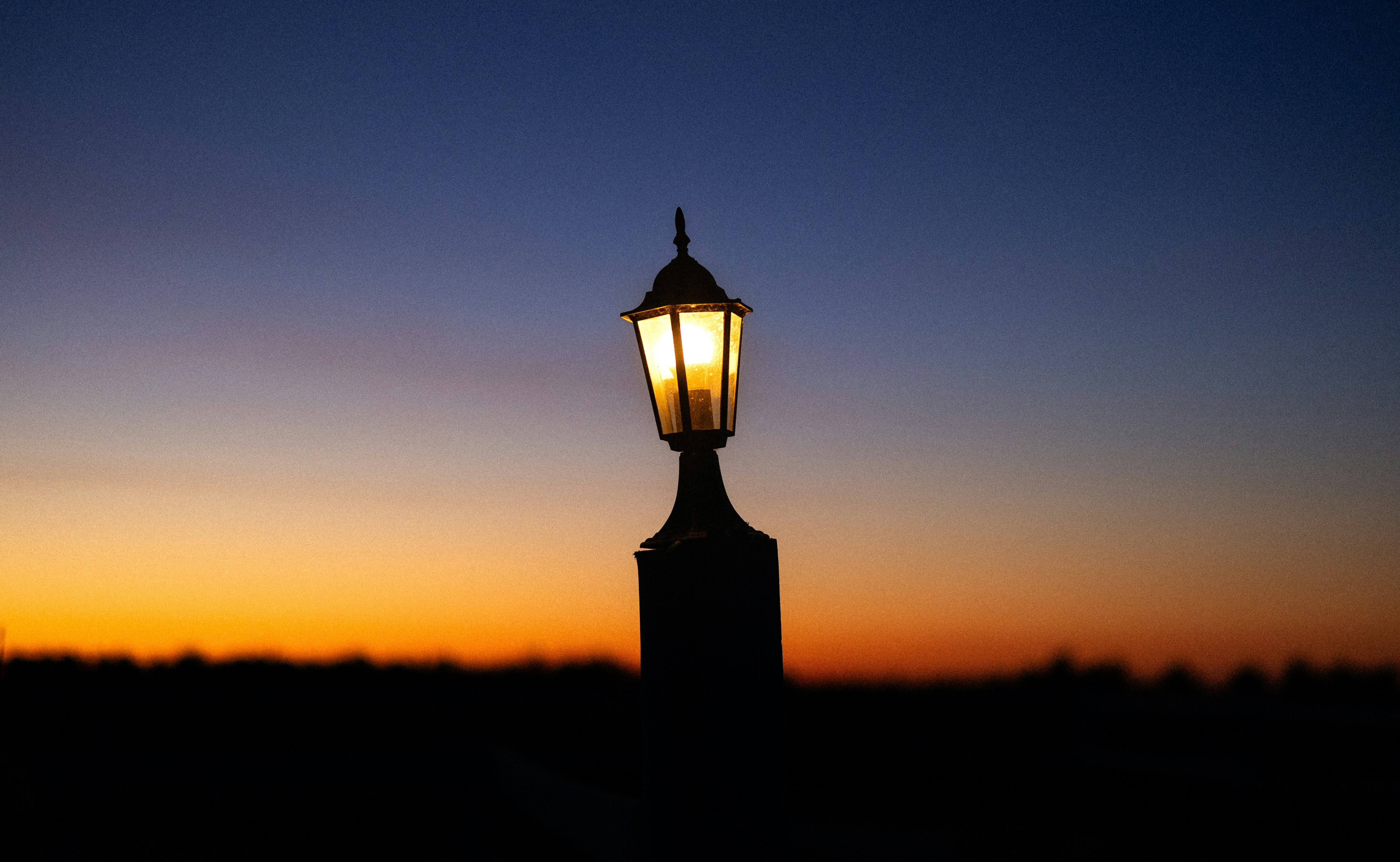 Beacon at Dusk: A solitary lamp carving warmth into a fading horizon