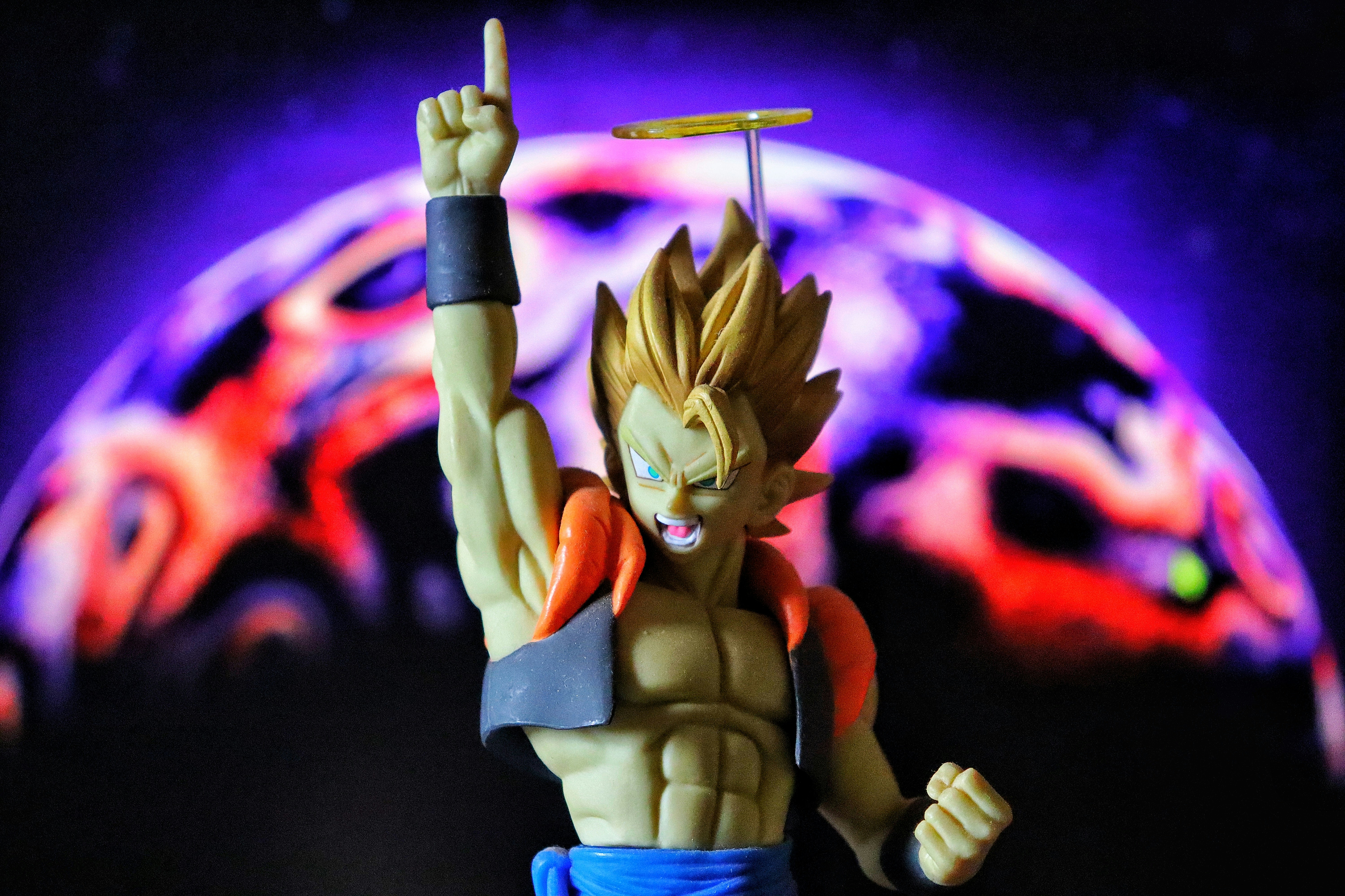 Anime-inspired figure with spiky hair and raised fist in front of a cosmic backdrop.