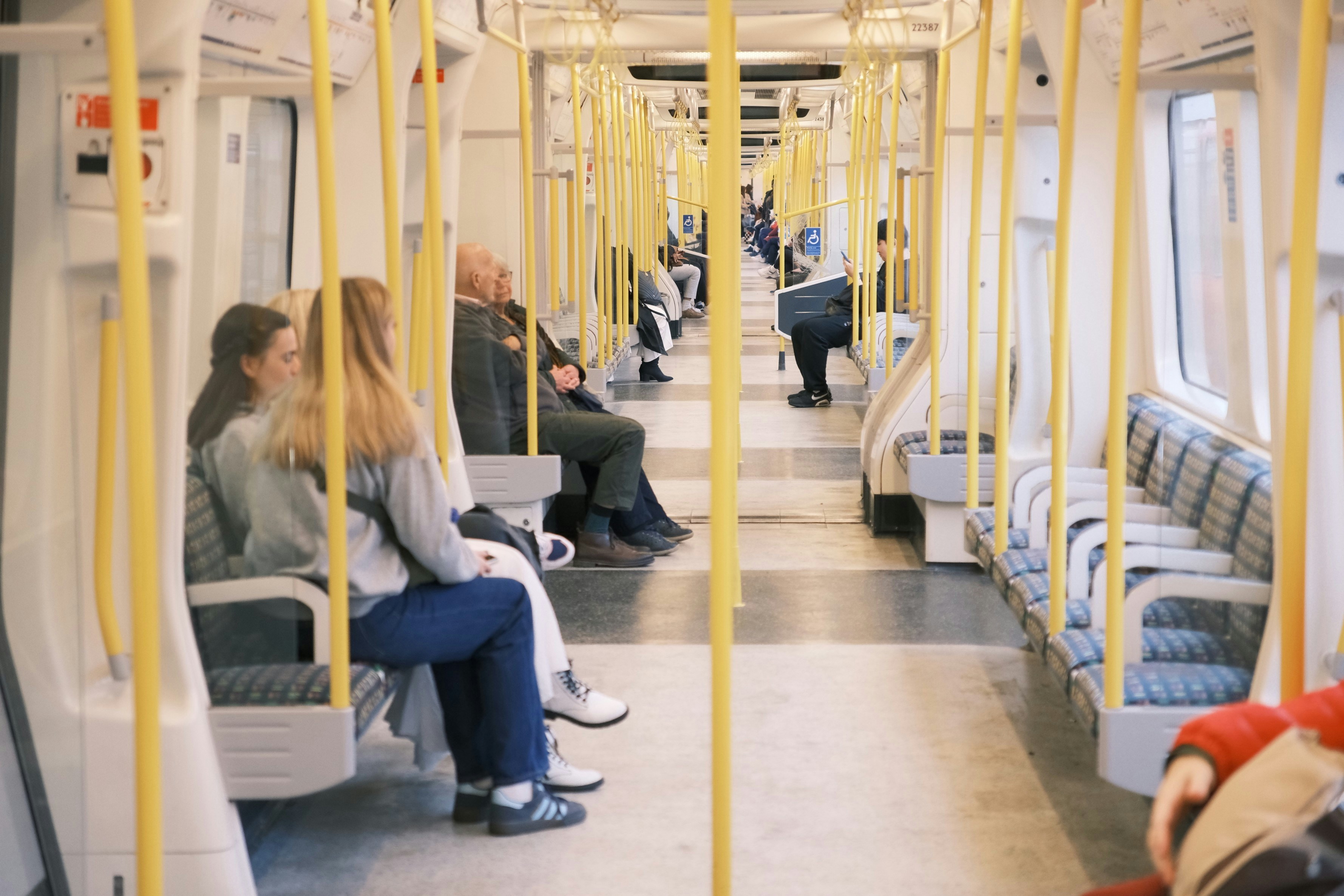 A group of people sitting on a train next to each other photo – Free ...