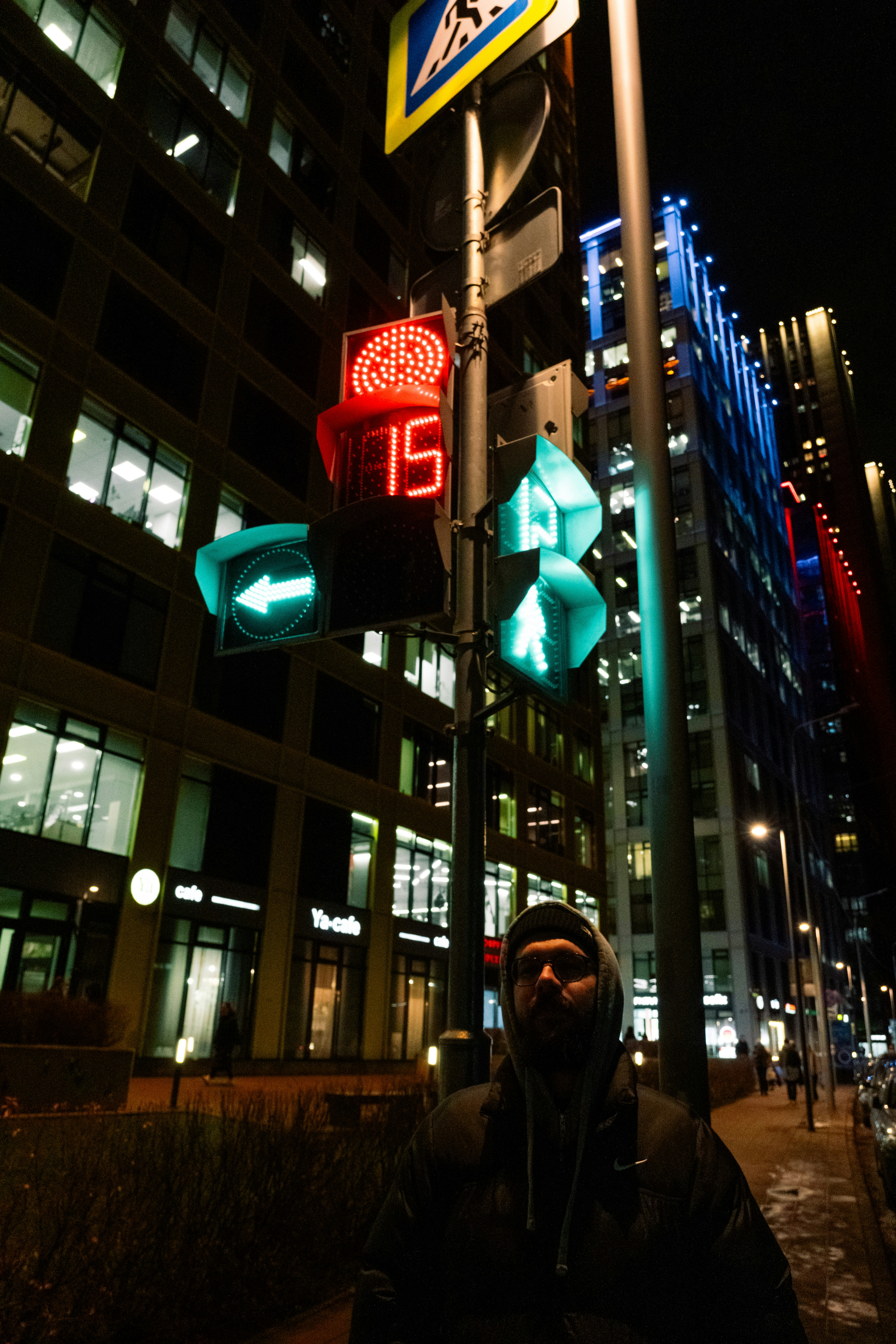 A man standing under a street light next to a tall building photo ...