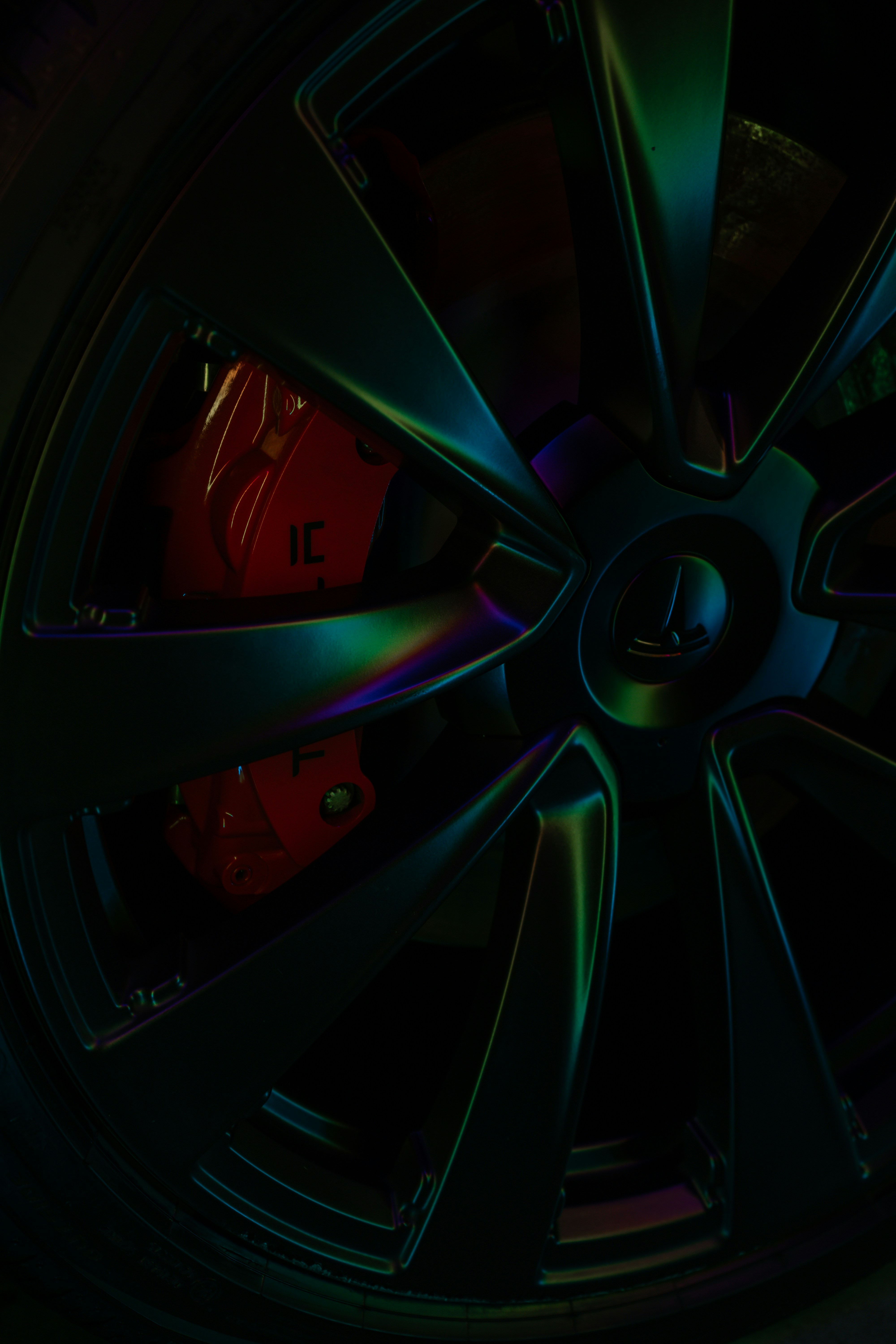 Iridescent Alloy Wheel: Neon Reflections on a Crimson Caliper
