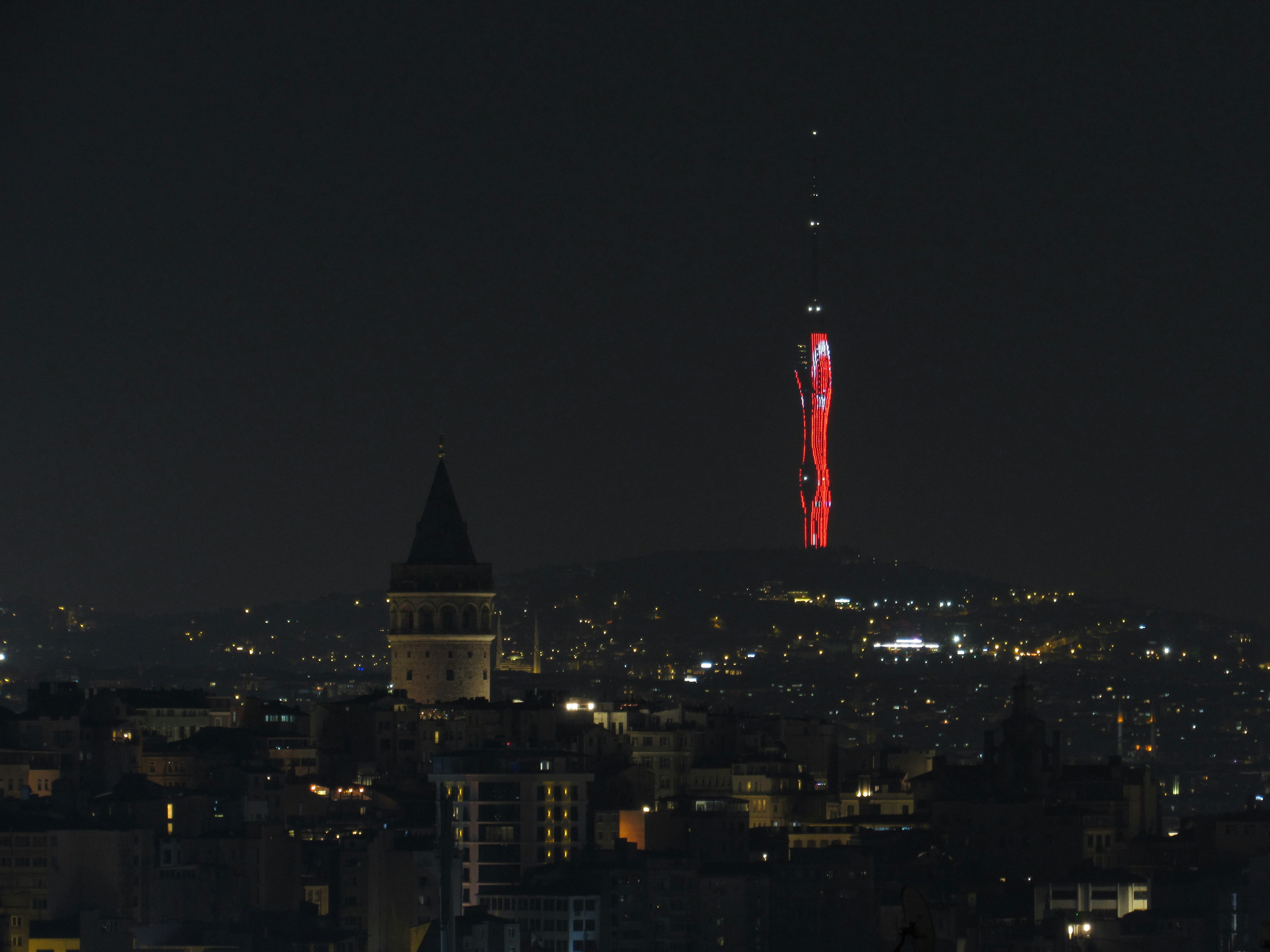 Crimson Neon Spire Slicing the Night Above a Historic Skyline