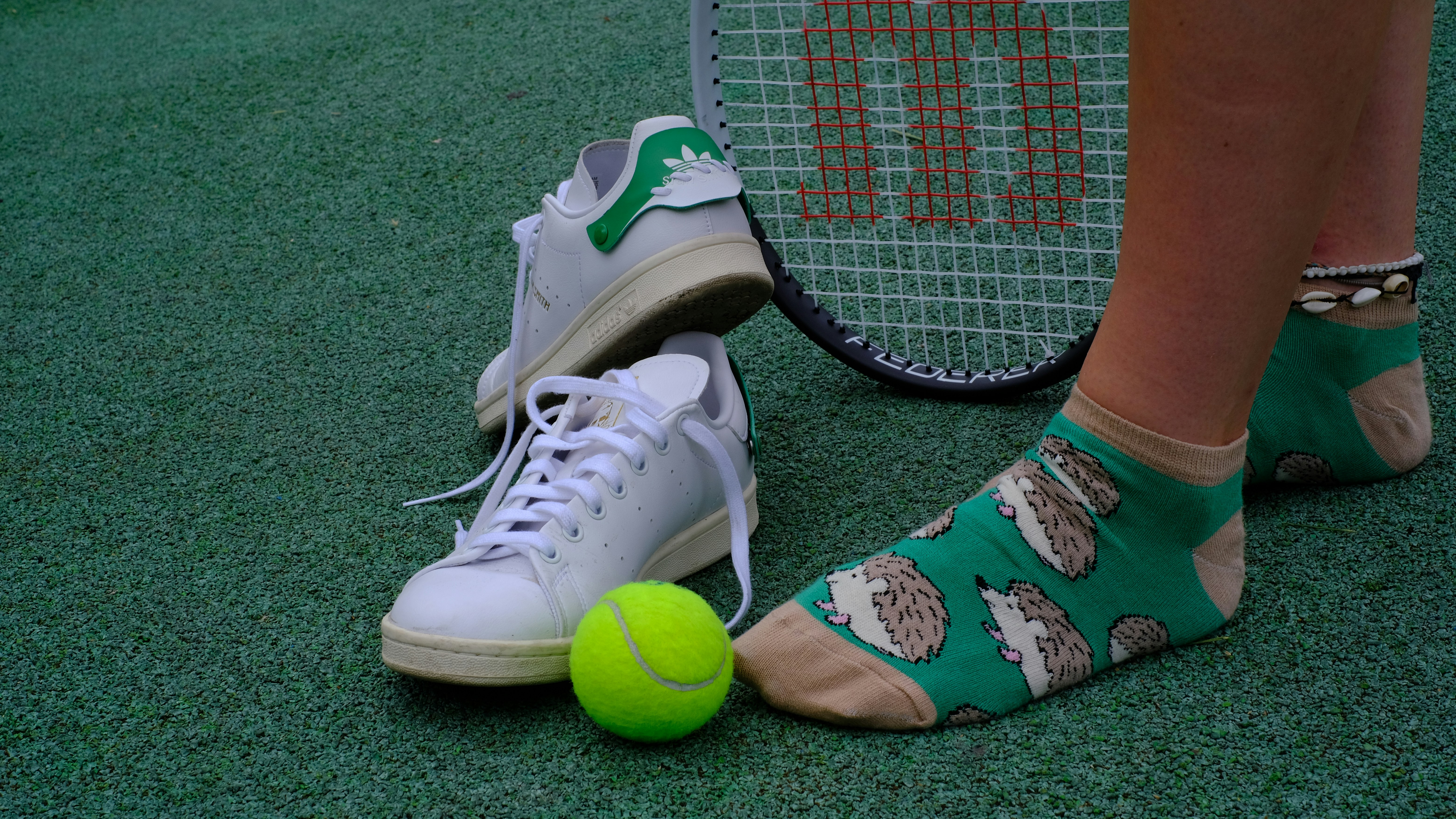 A tennis player's feet with a tennis racket and a tennis ball photo ...