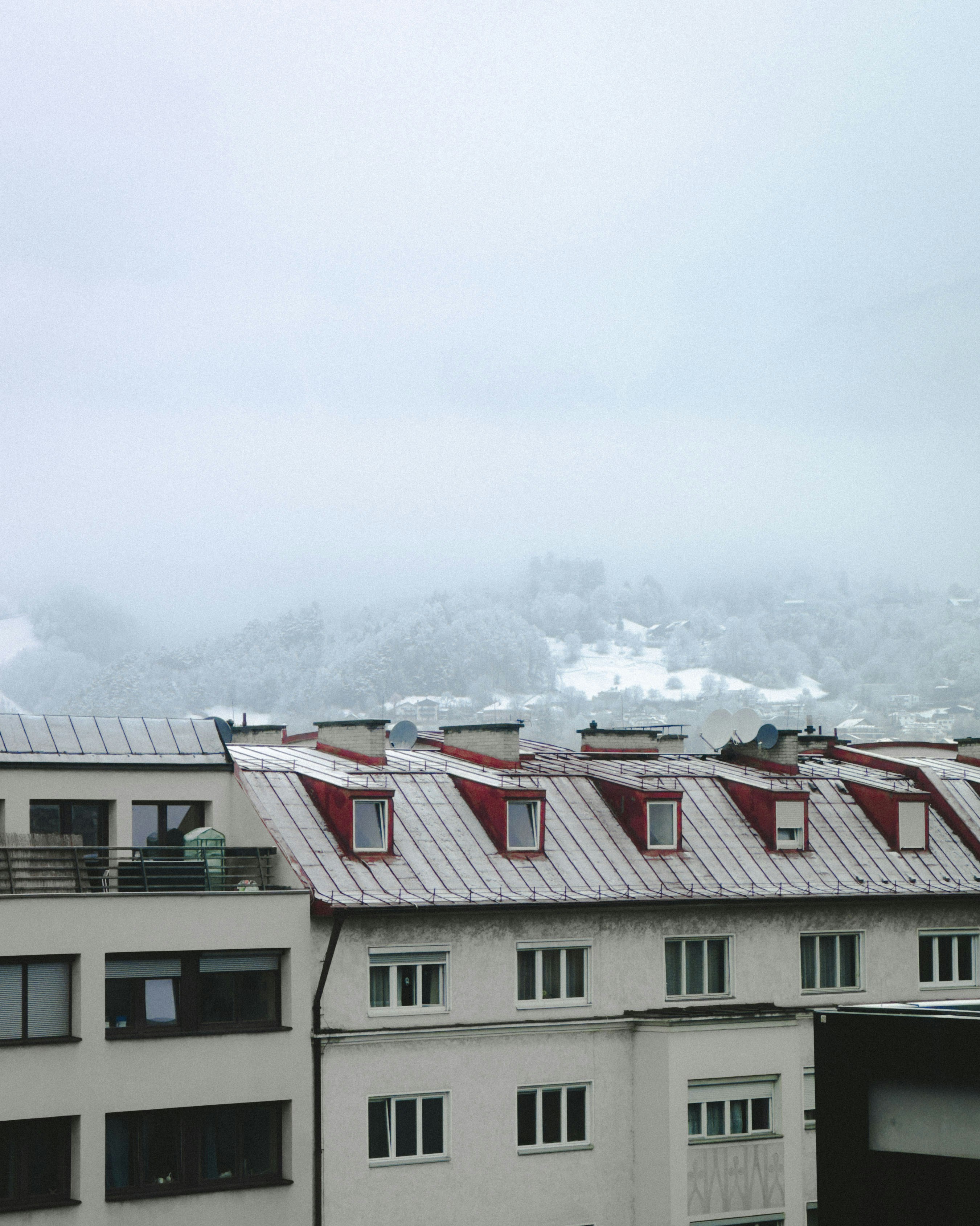 Red Roofs in a Quiet Winter Haze Over a Muted Cityscape