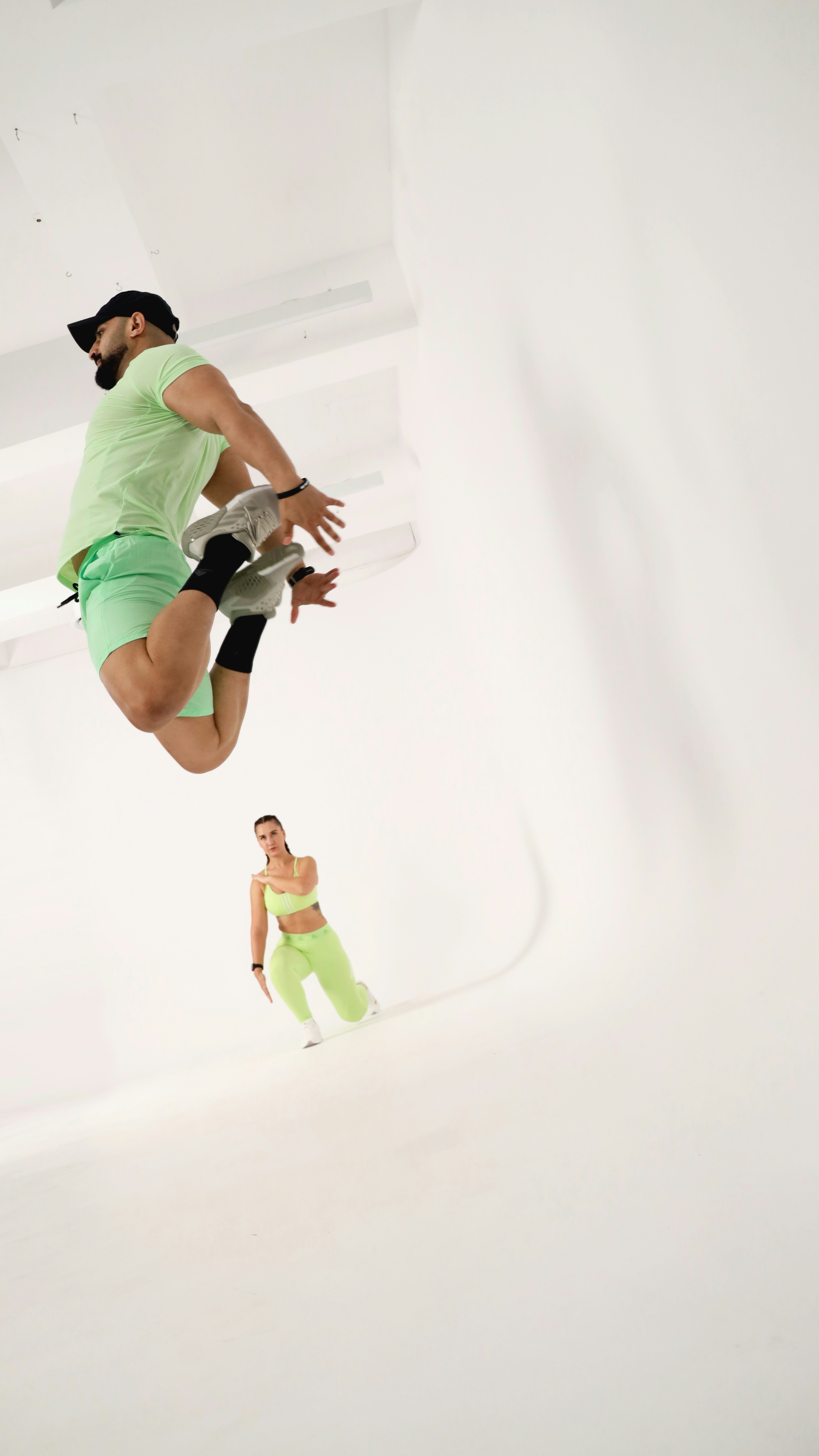 Leap of Neon: A duo of athletes suspended in a bright white studio