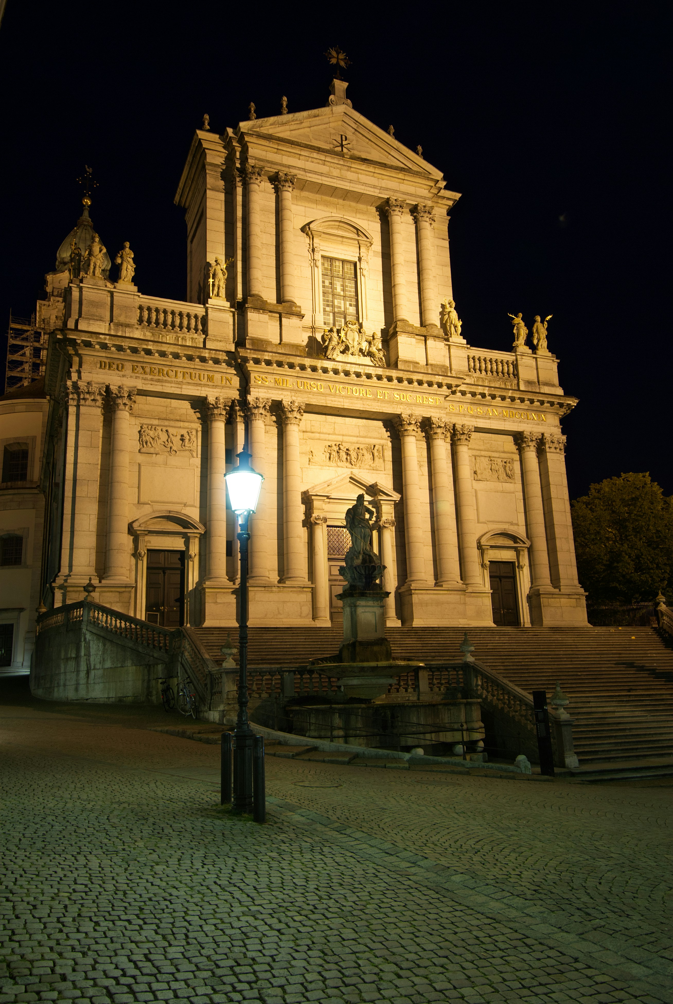 Warm Illumination on a Monumental Facade: Night Portrait of a Classical Temple with Statue and Fountain