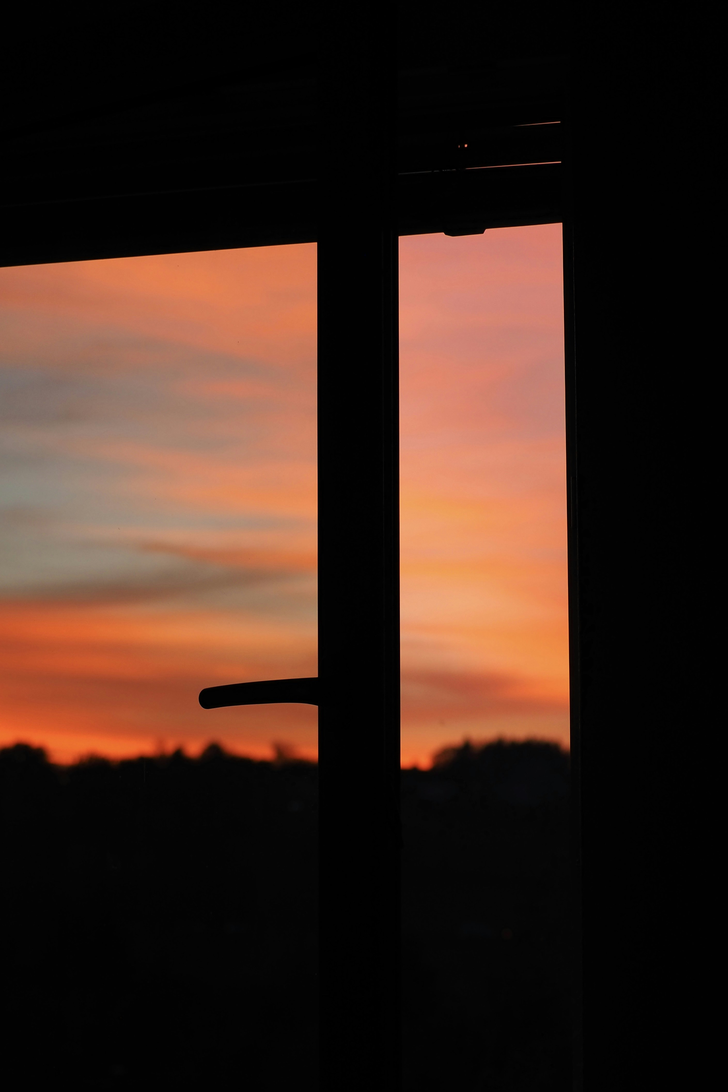Crimson Windowlight: Sunset Framed by Shadowed Glass