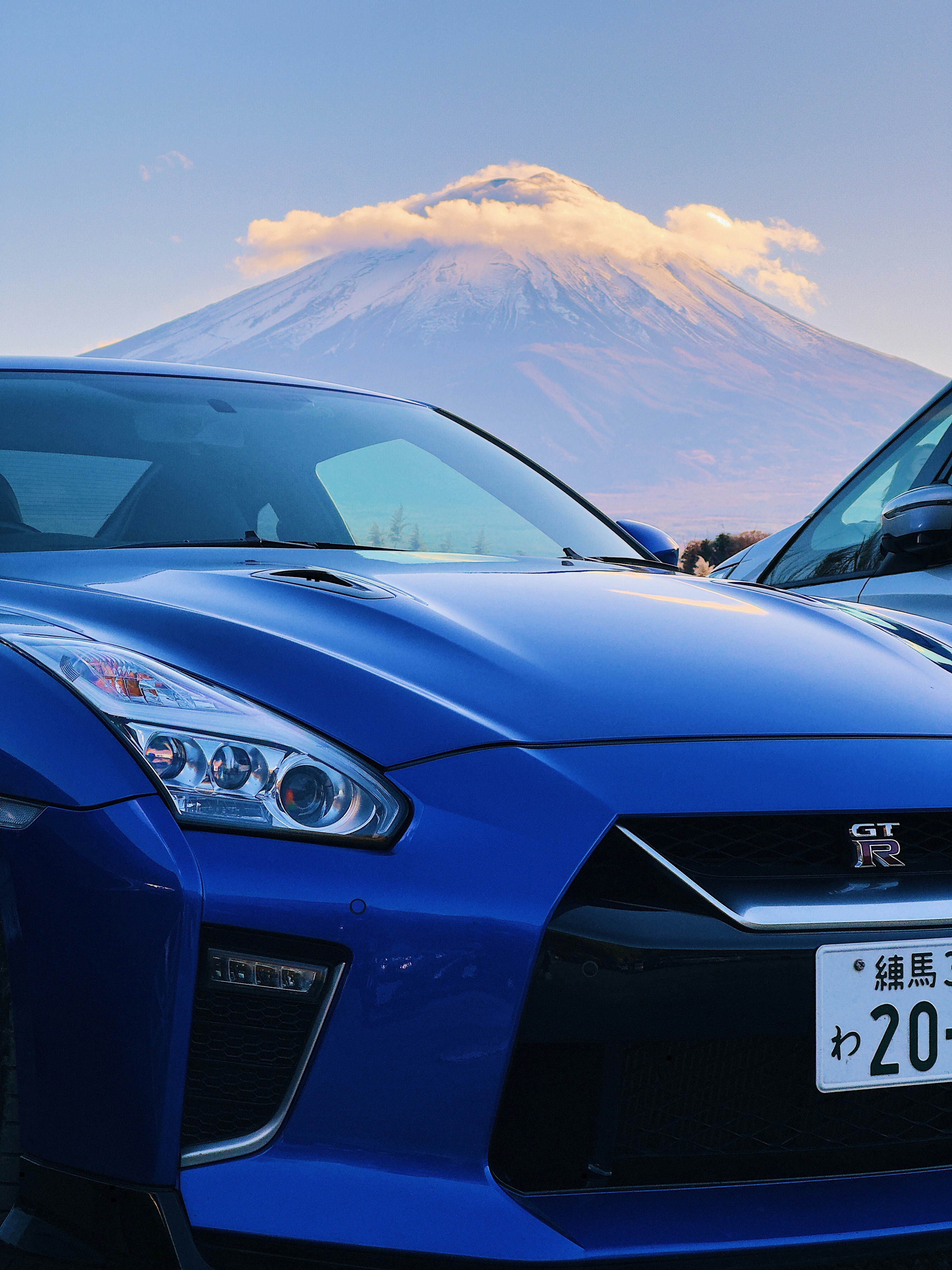 Blue Nissan GT-R Front View Framed by Mount Fuji's Snow-Capped Peak