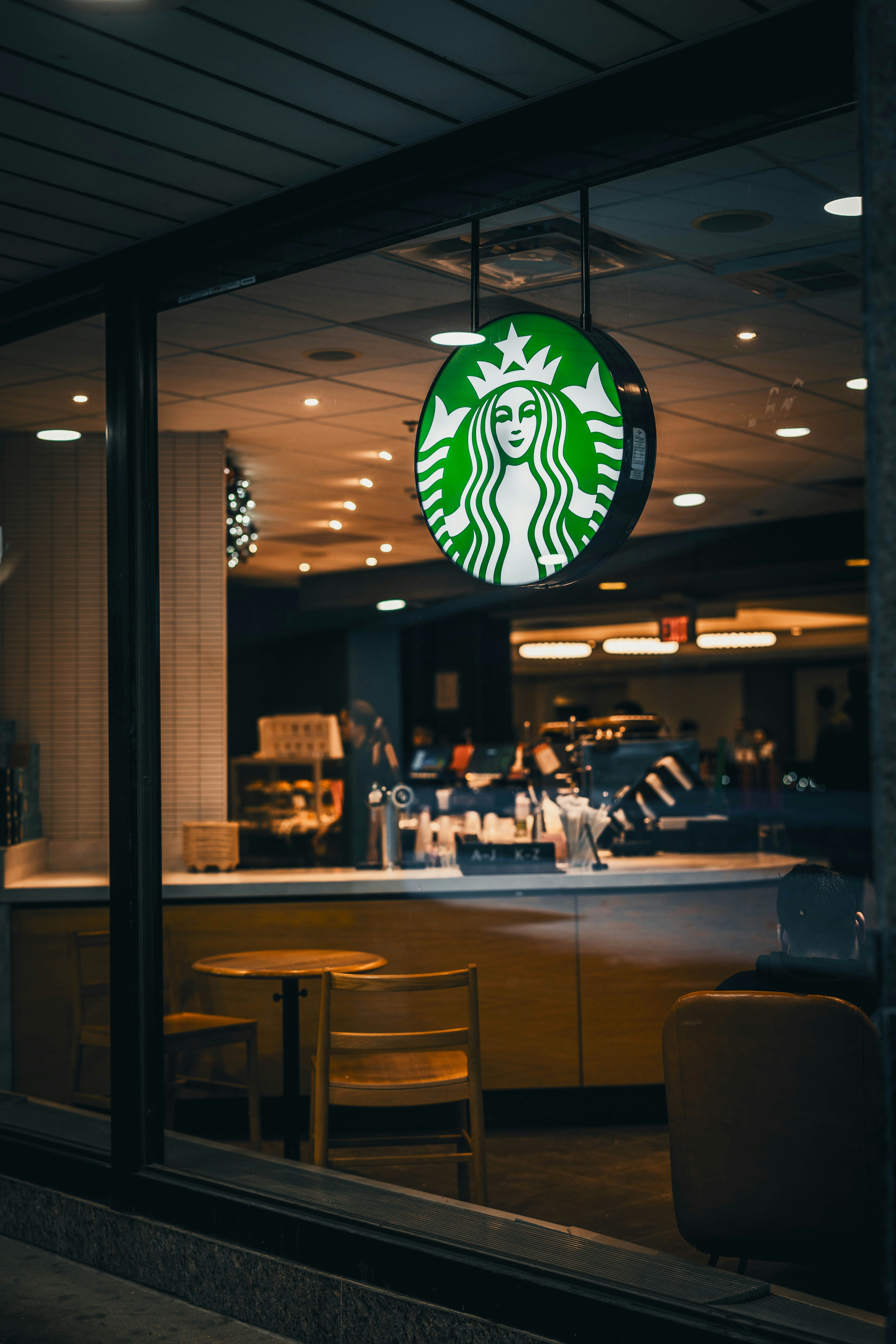 A starbucks sign hanging from the side of a building photo – Free ...