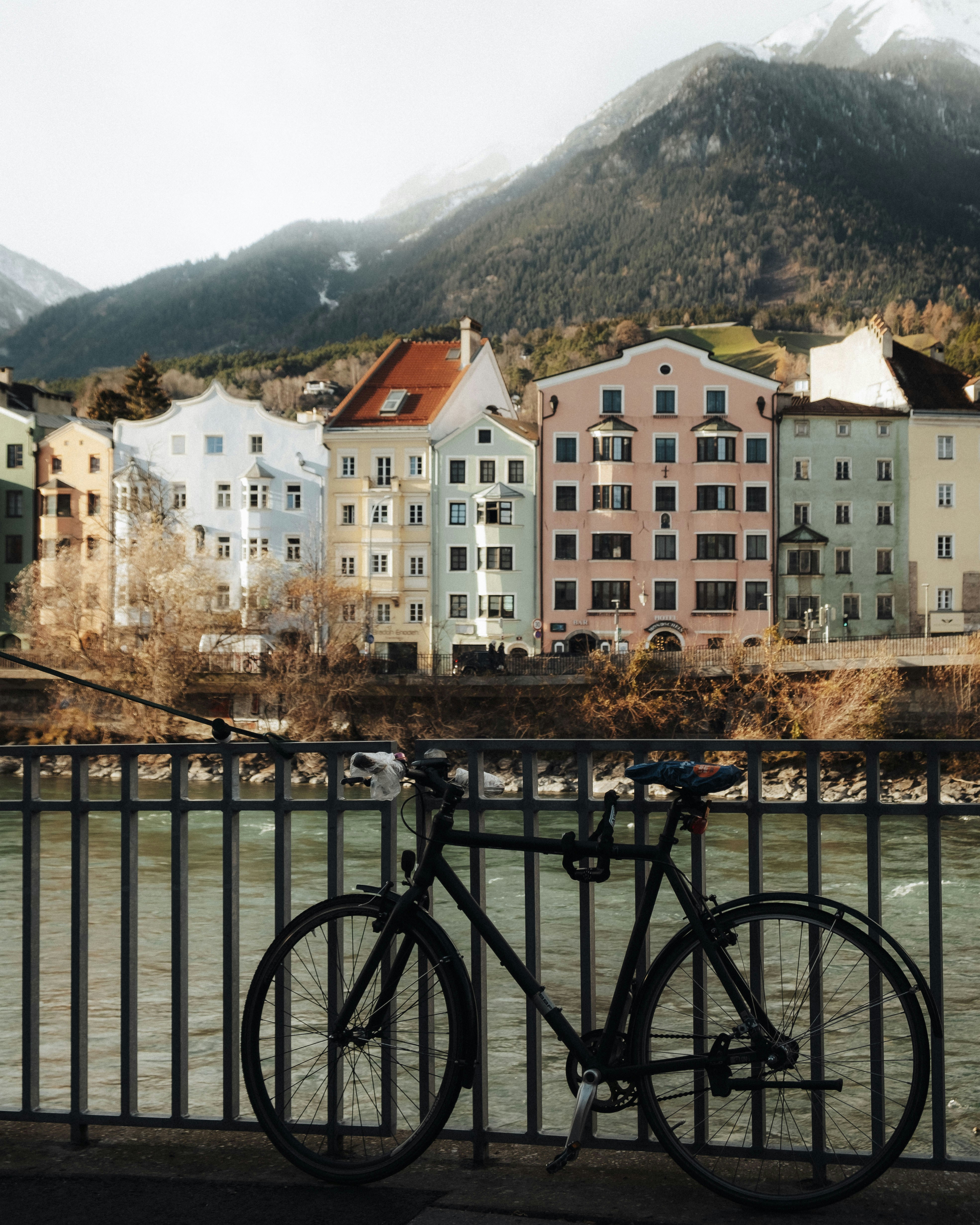 Colorful riverside pastel houses framed by a tethered bicycle