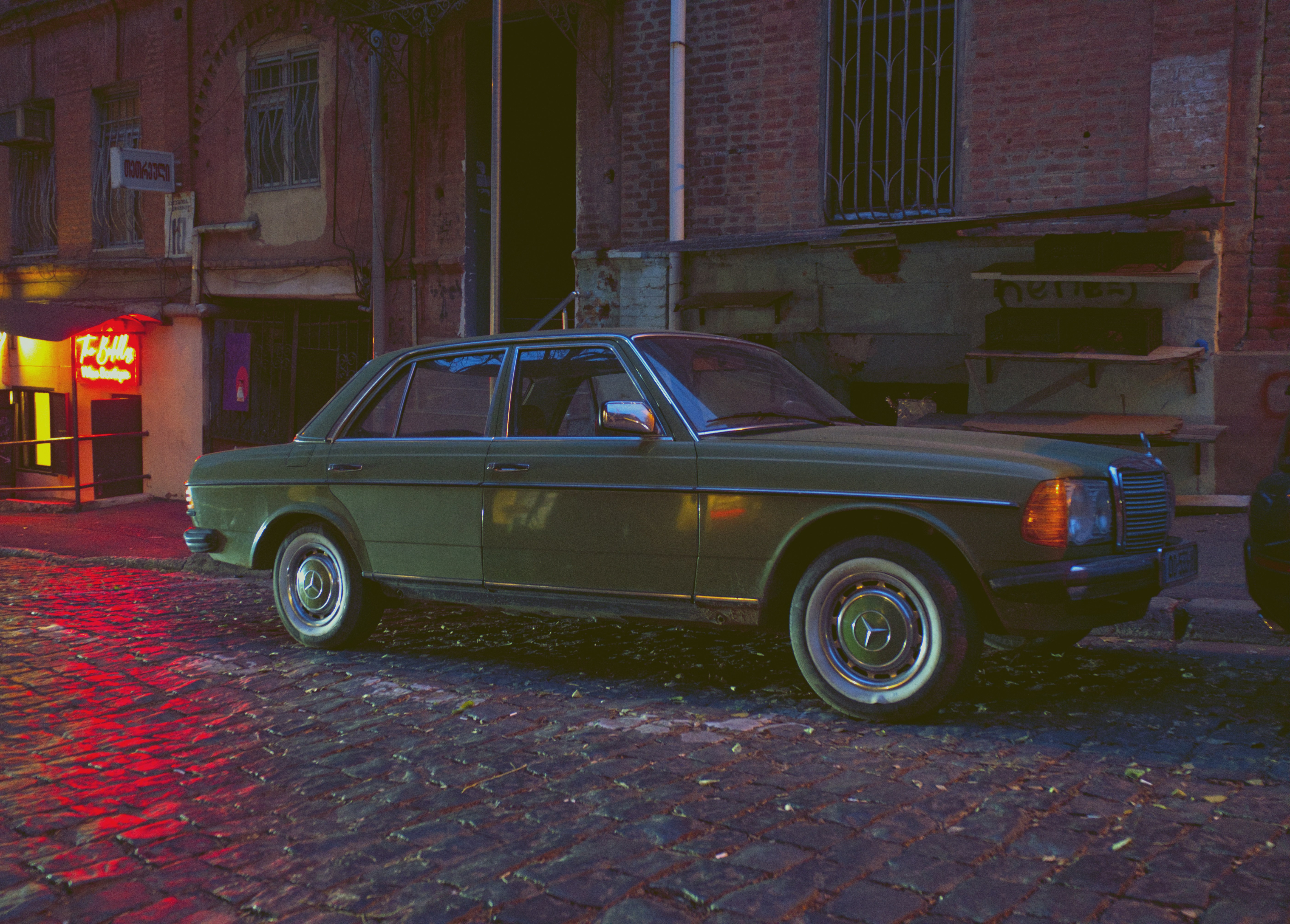 Midnight Neon and a Quiet Classic: Mercedes W123 on a Rain-Wet Street