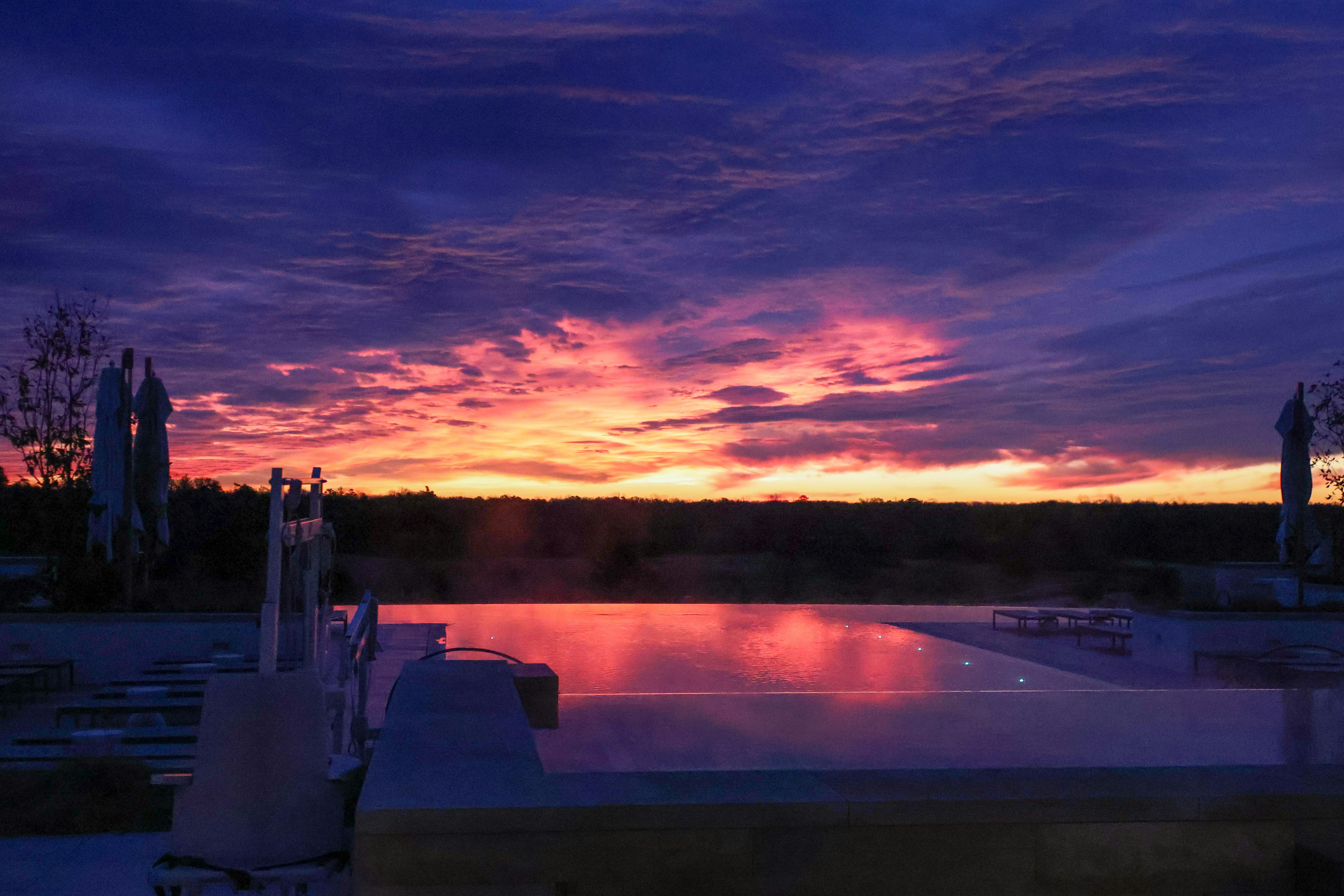 The sun is setting over a body of water photo – Free Keswick hall Image ...