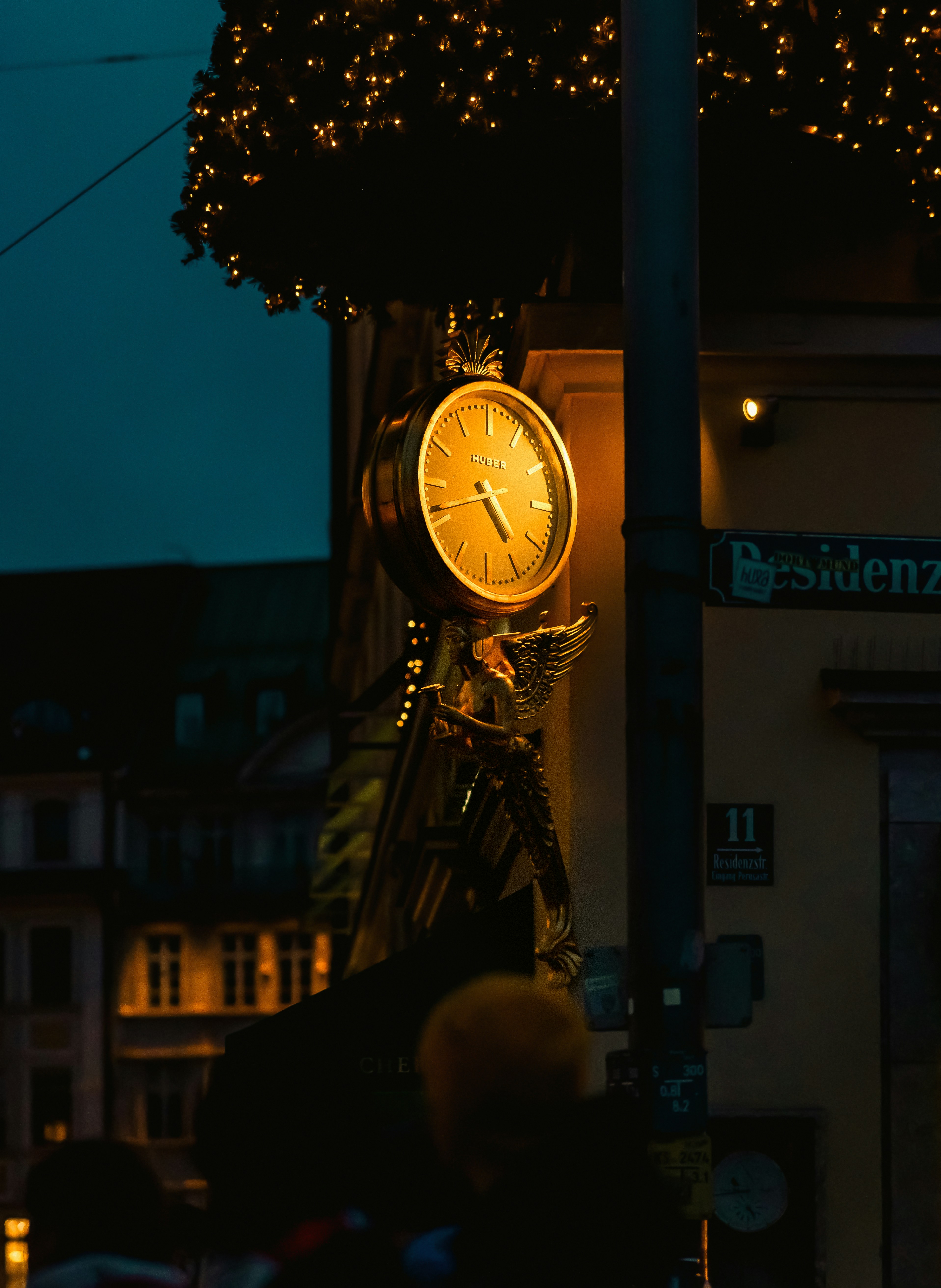 A clock on the side of a building at night photo – Free Wallpaper Image ...