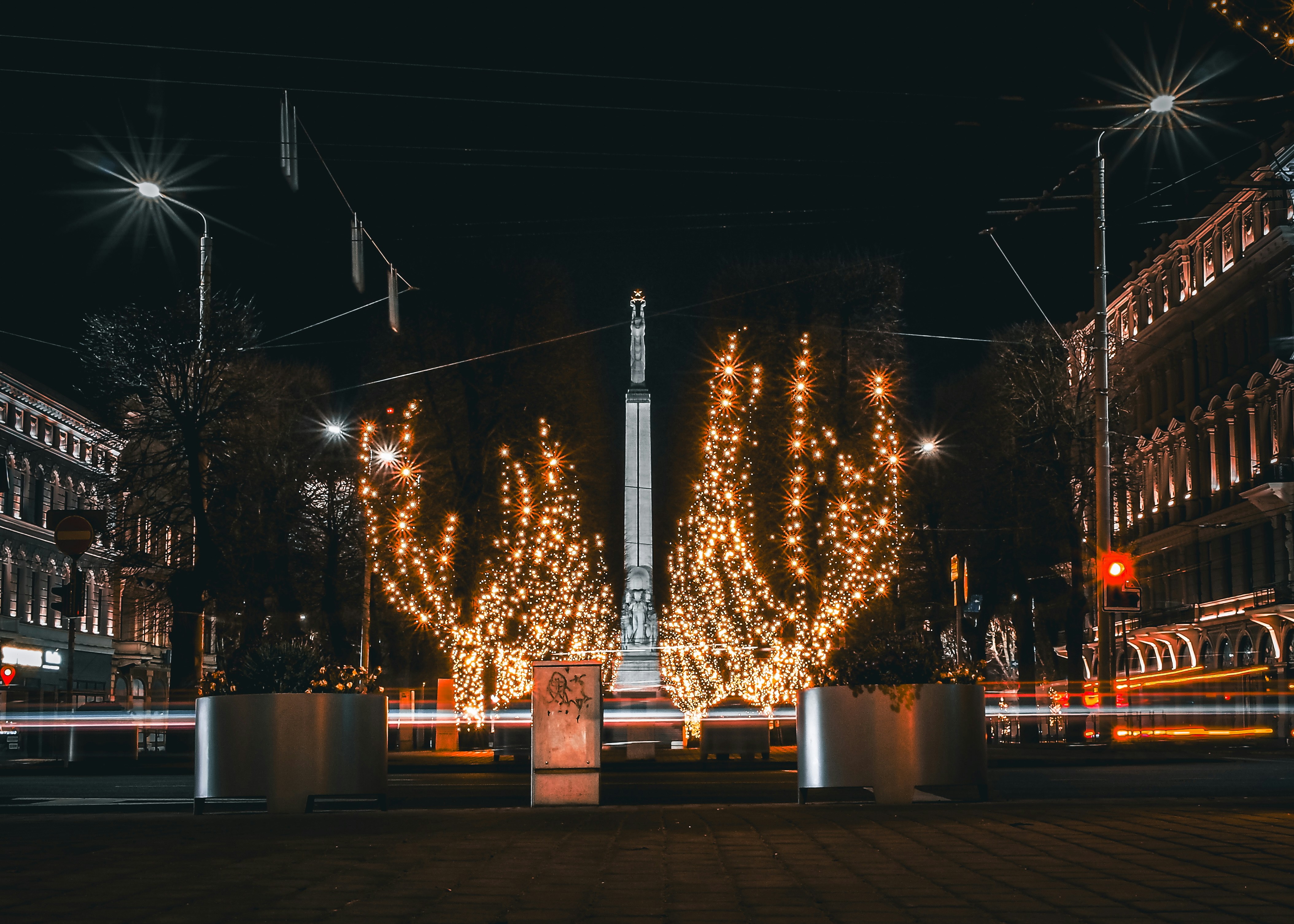 Monument in the Glow: Night-Lit Plaza Framed by Fairy-Lit Trees