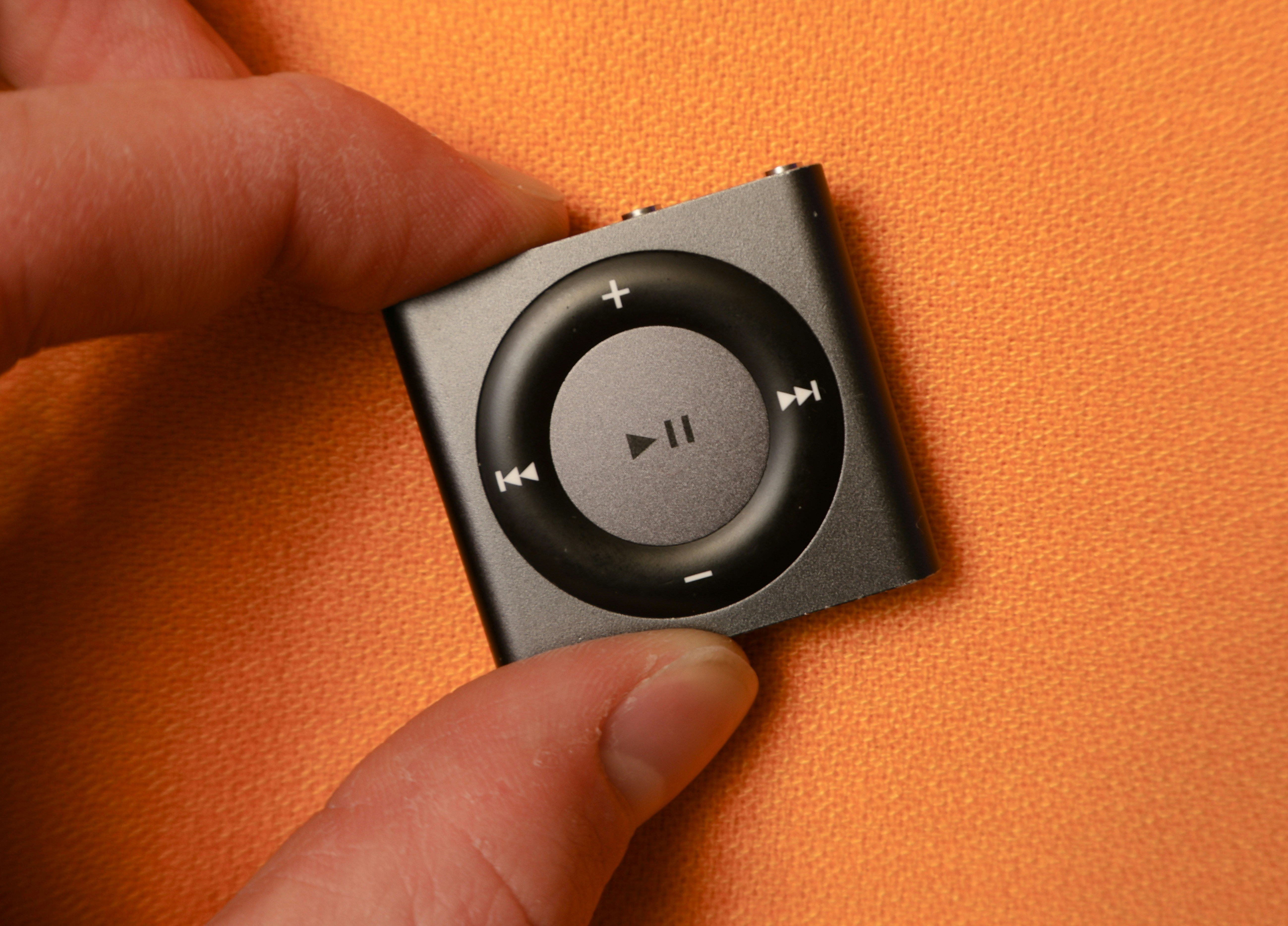 A hand holding an mp3 player over an orange surface photo – Free Music Image on Unsplash