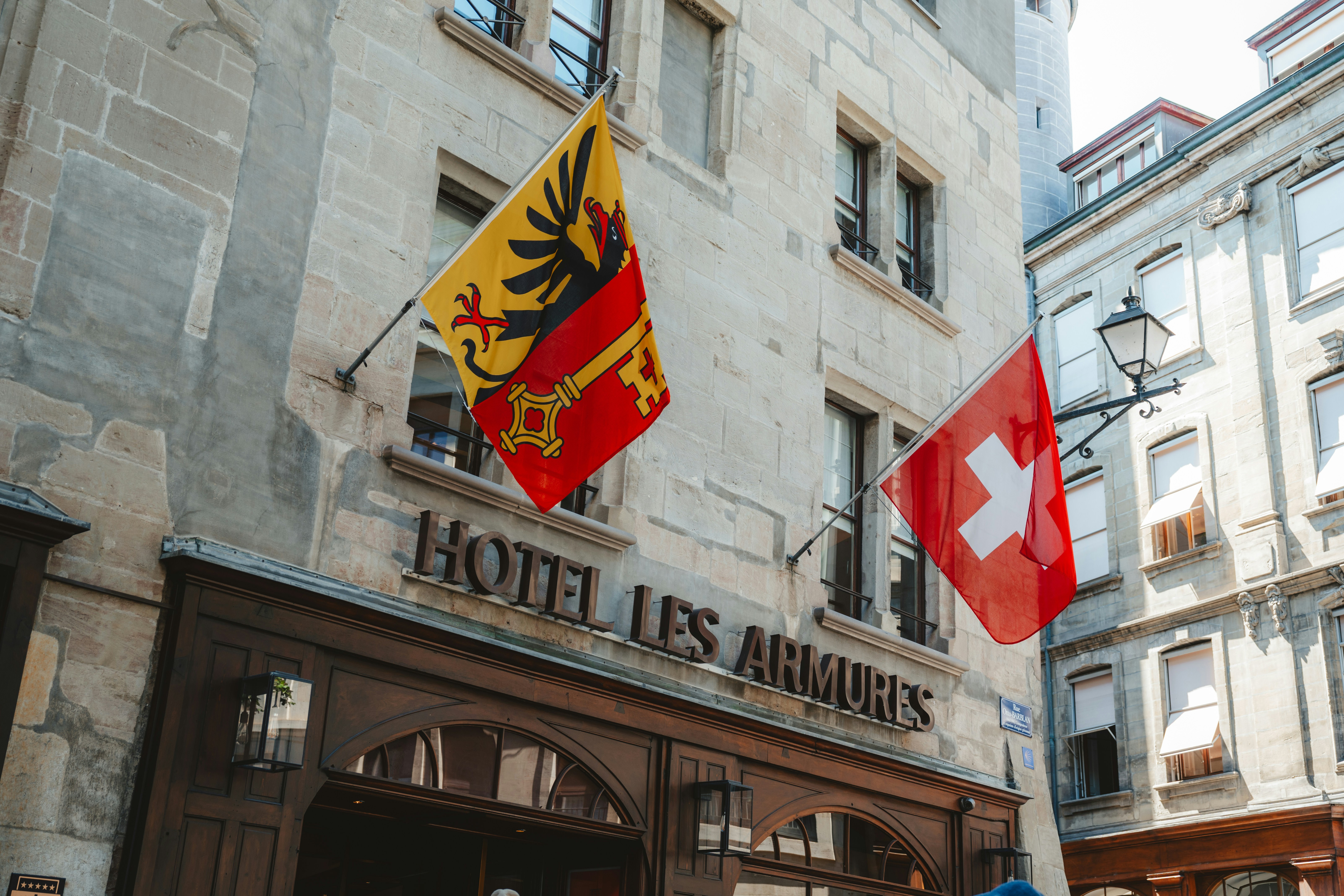 Flagged Facade of Hotel Les Armures: Old Town Stone and Emblems