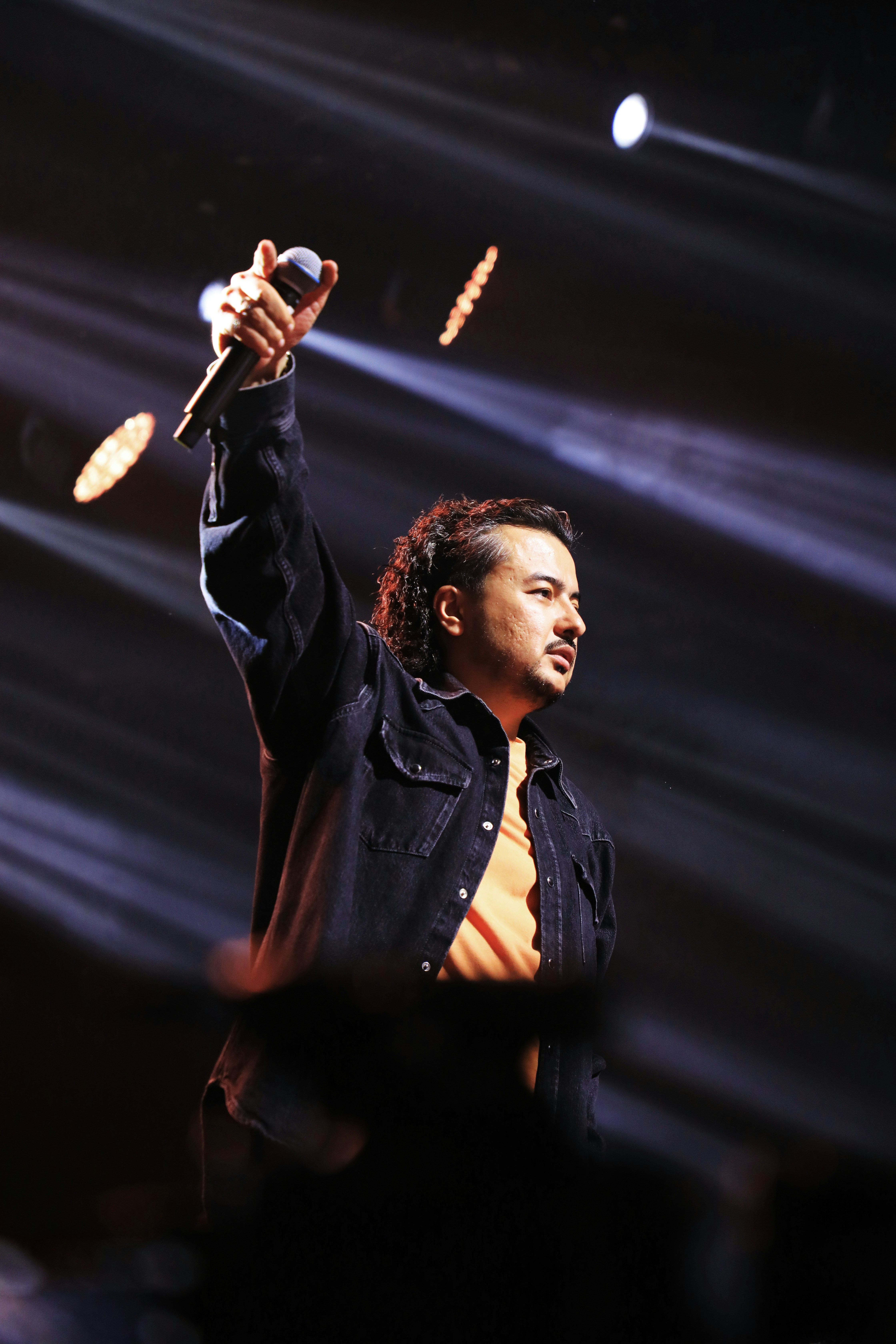 Midnight Mic Lift: A Vocalist Commands the Stage Under Streaking Lights