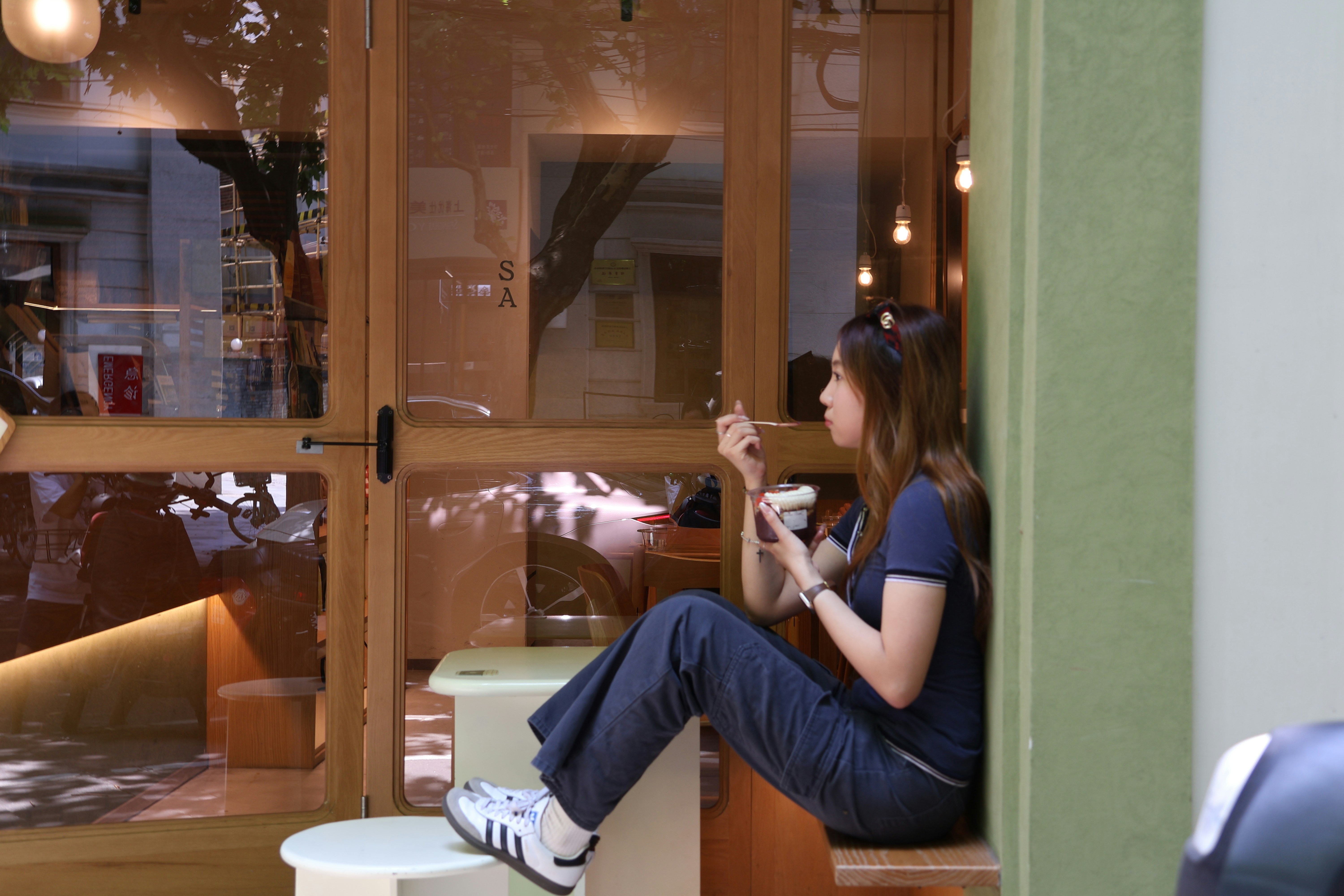 Window-Side Pause: A Quiet Café Moment Framed by Glass