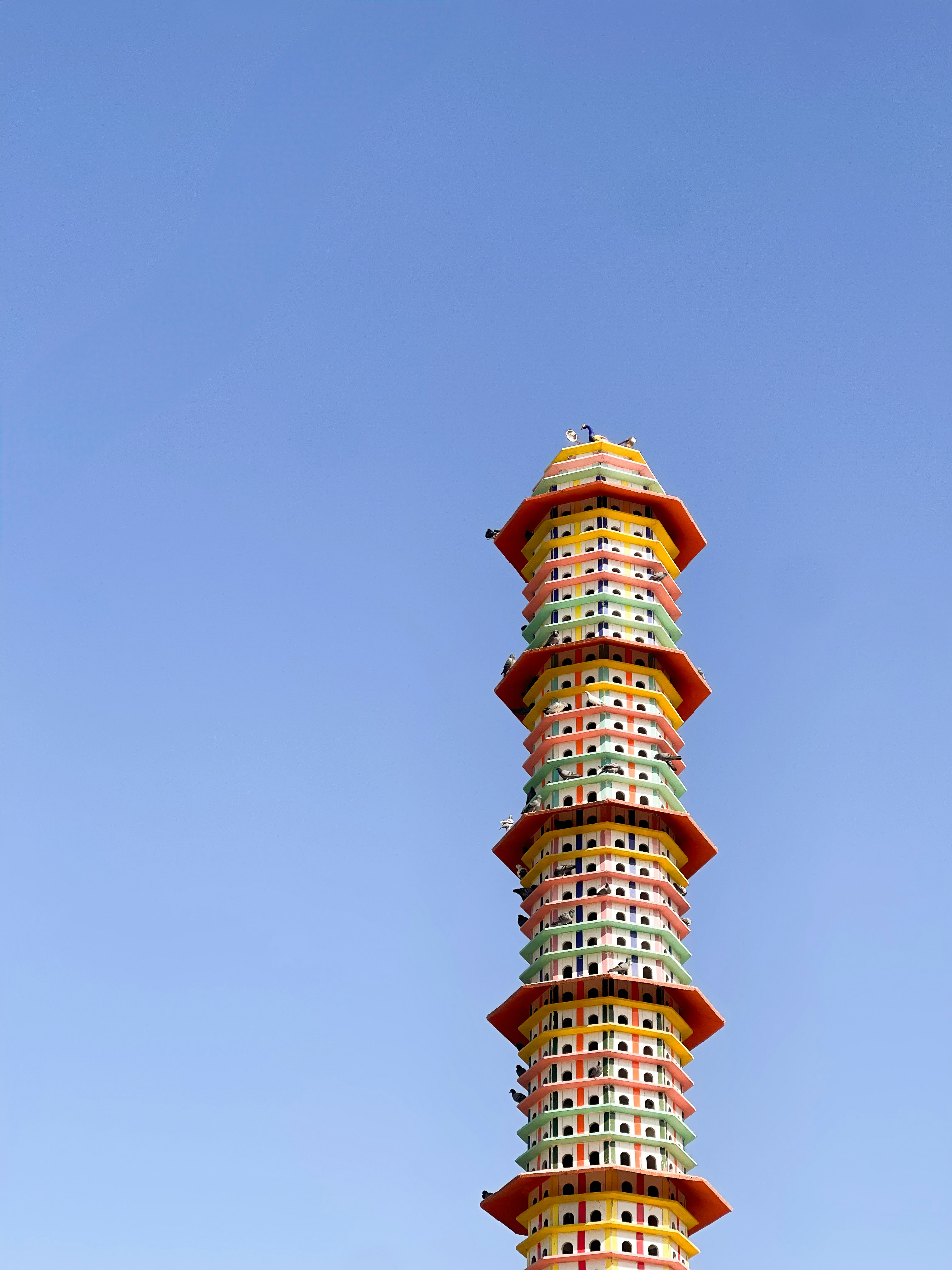 A tall tower made of many different colored objects photo – Free Bird ...