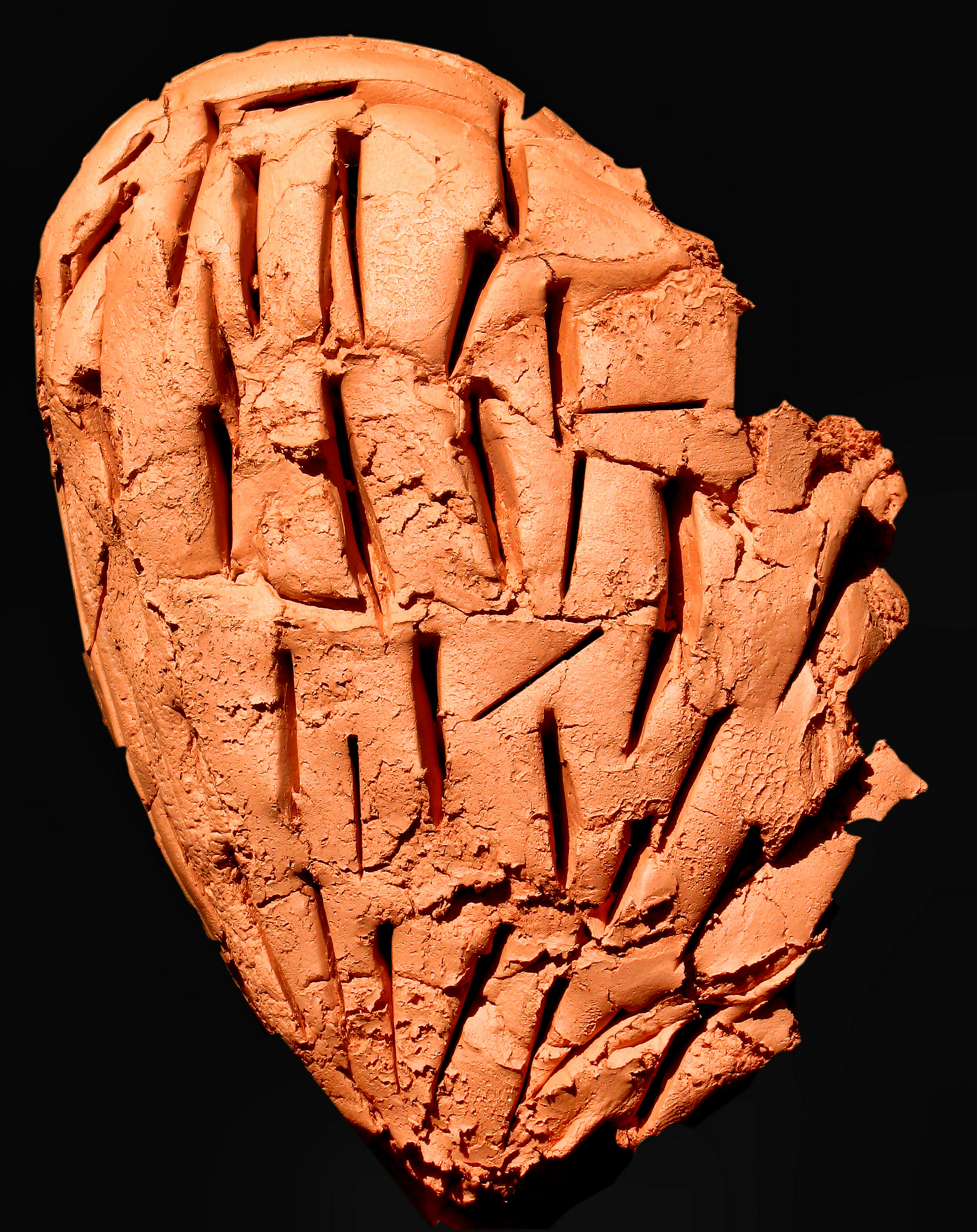 A heart made of red clay with stab wounds