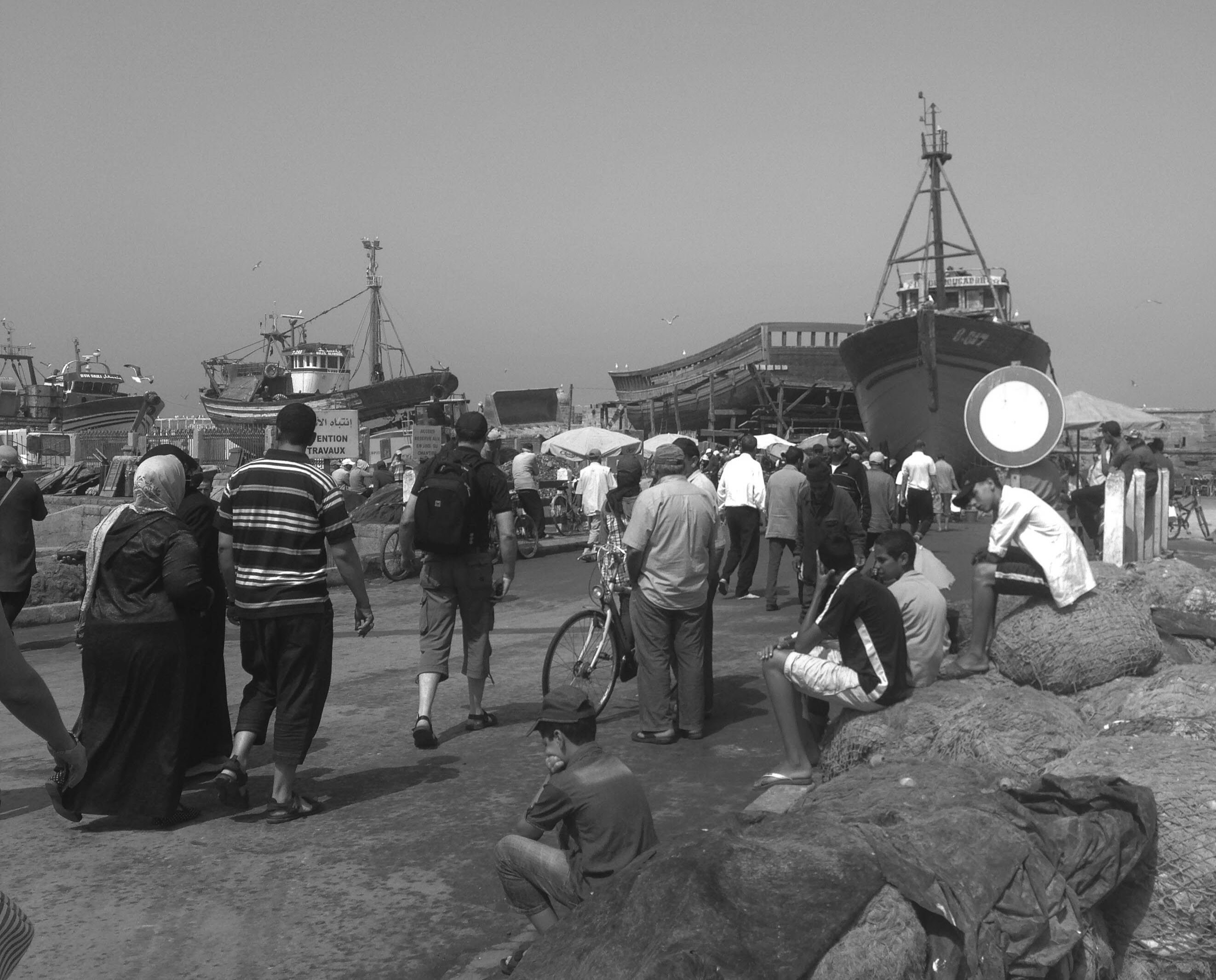 Harbor Crowds at Dusk: Boats and Bystanders on a Windy Pier
