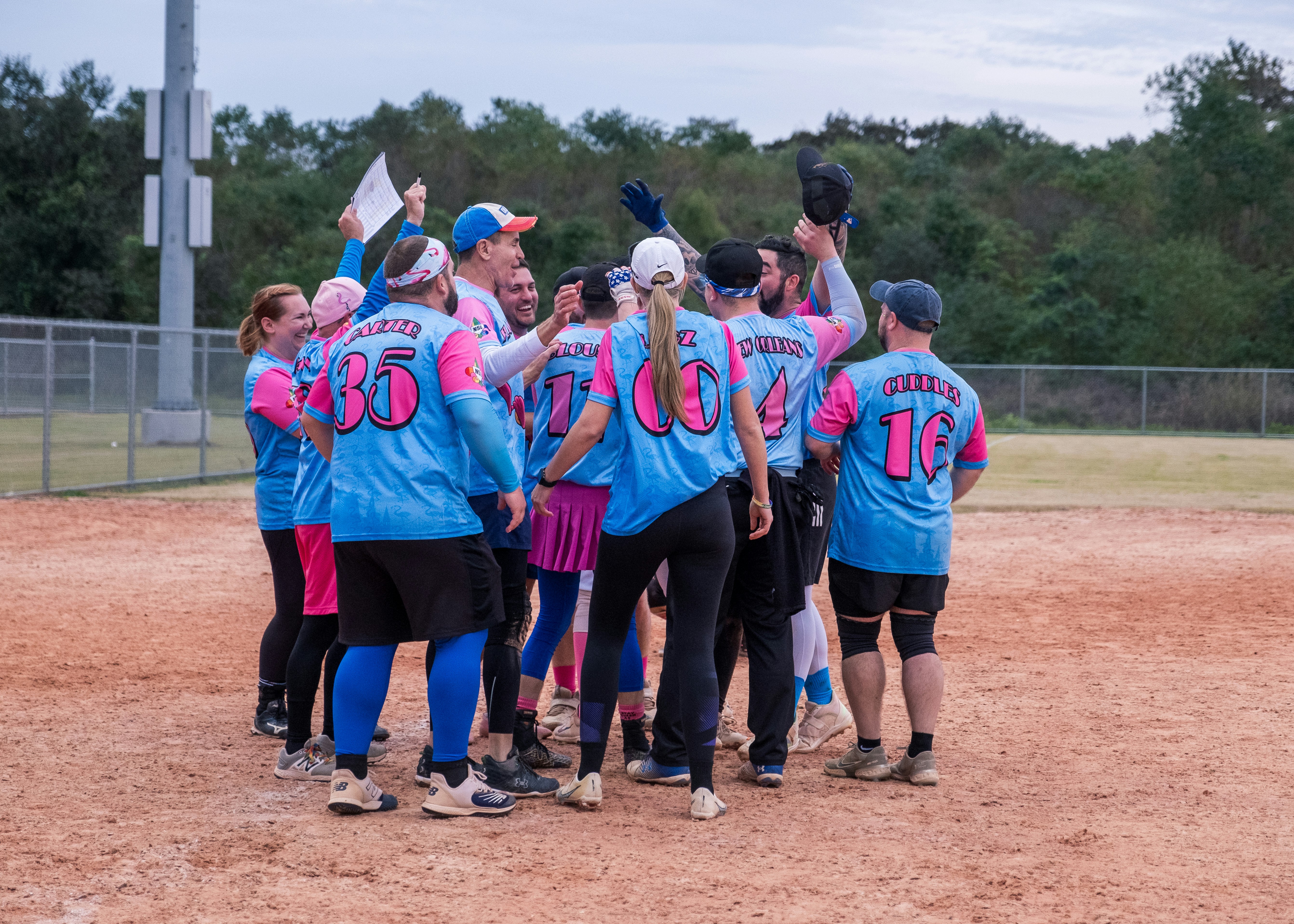 A group of softball players standing on top of a field photo – Free ...