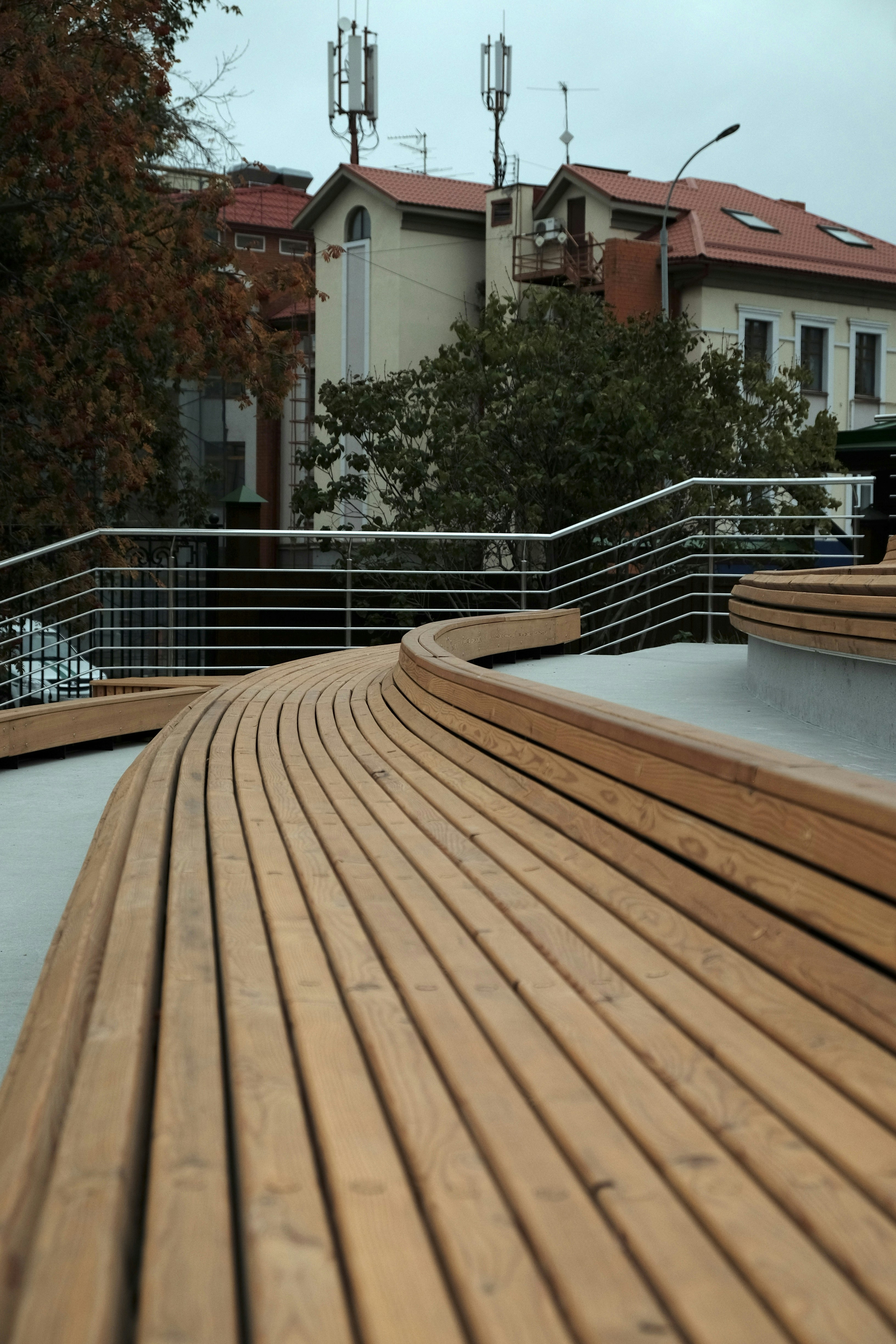 Curved Cedar Promenade on a Rooftop Overlooking the City