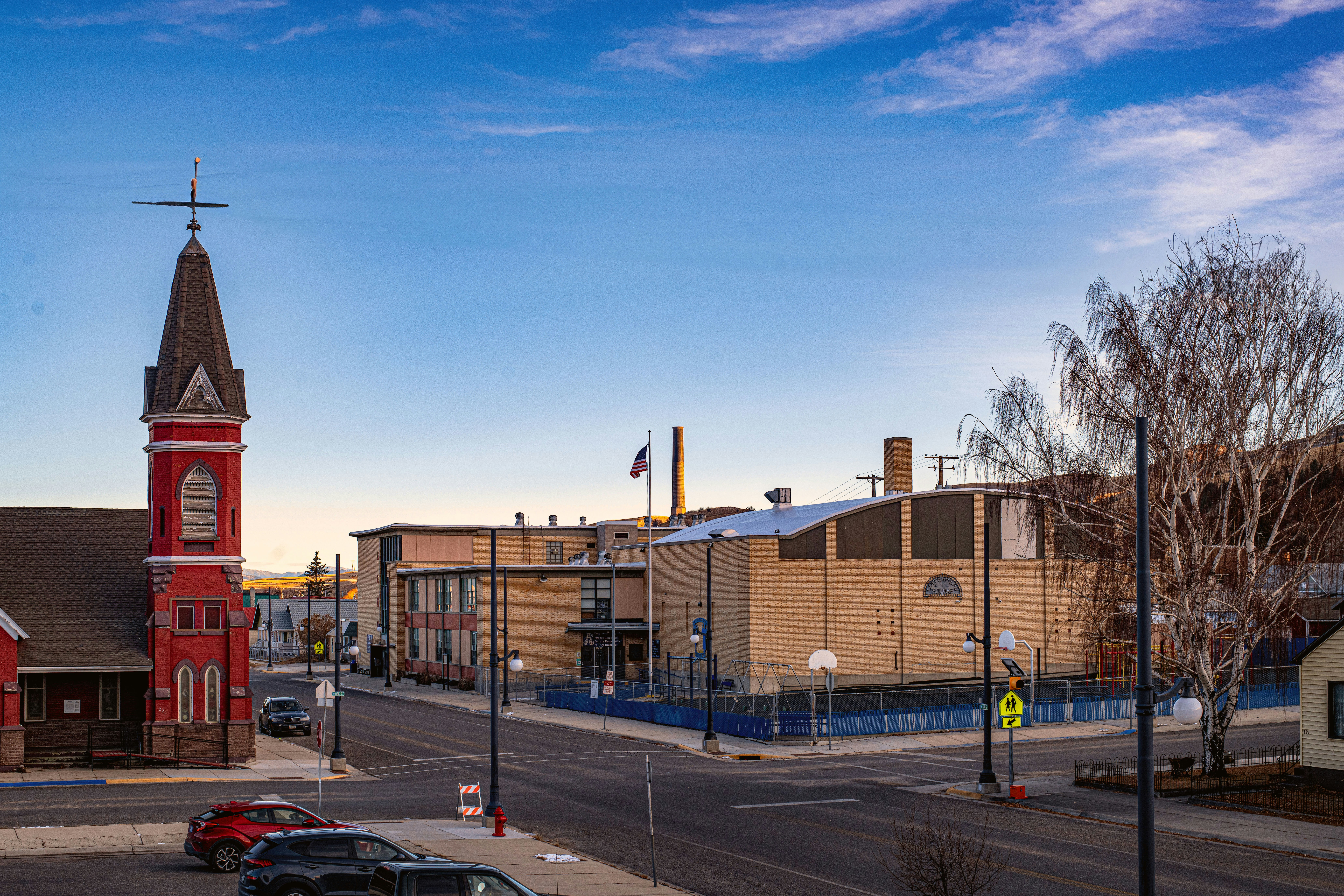 Crimson Clock Tower Framing a Quiet Main Street Under a Clear Blue Sky