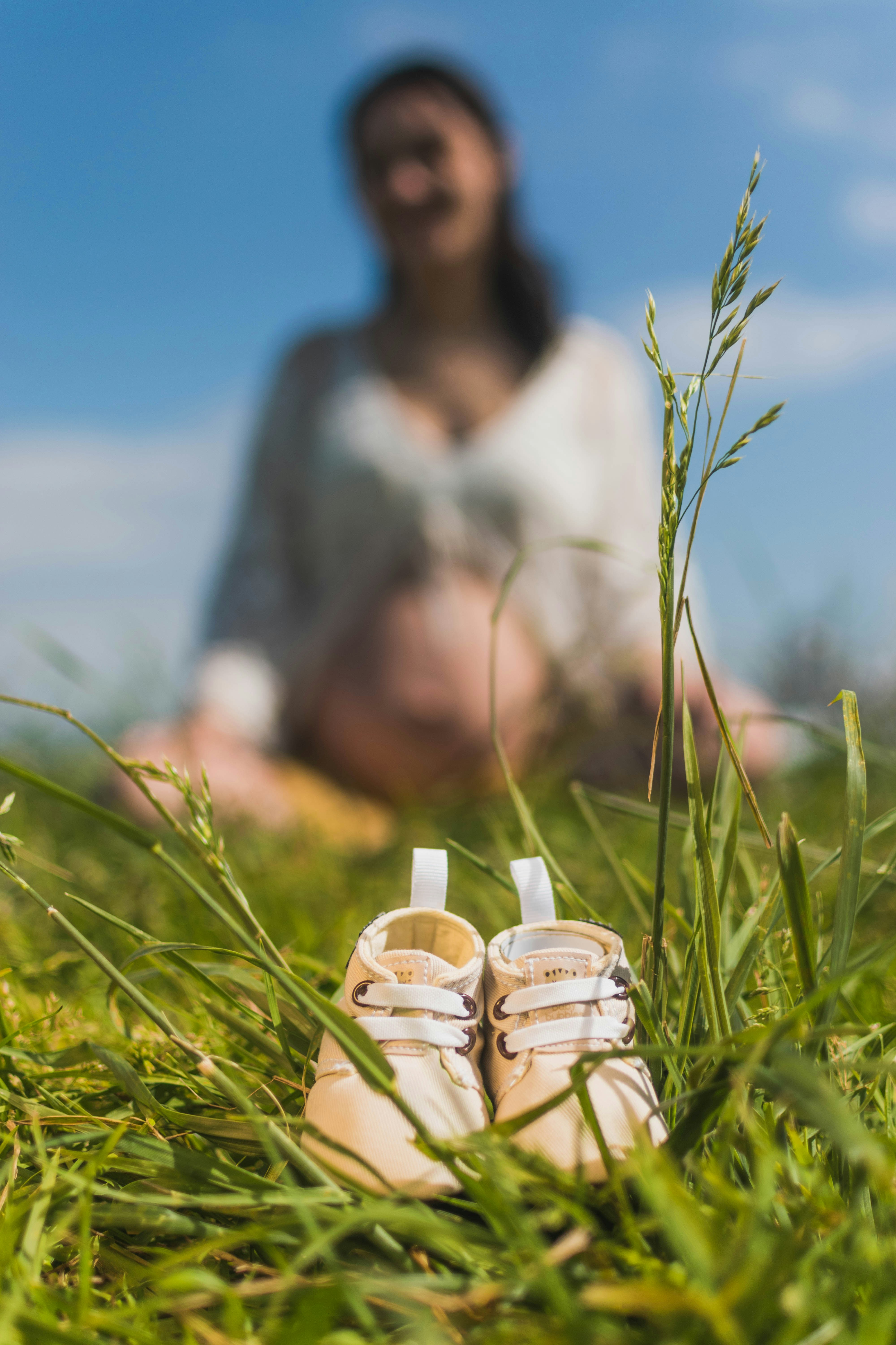 Barefoot Field Expectation: Shoes Rest in Grass as a Mama Laughs in the Blur