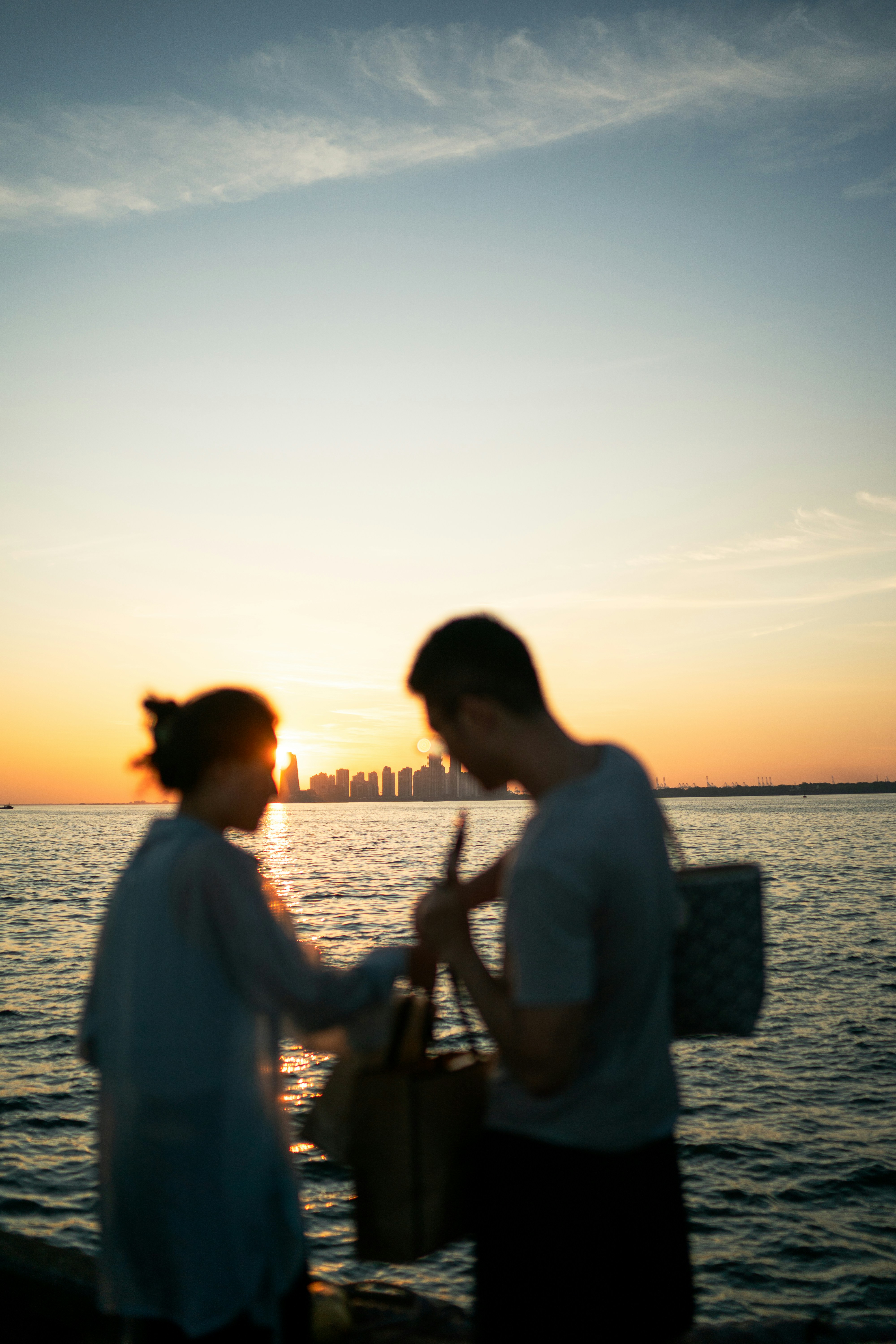 A man and a woman standing next to each other near the water