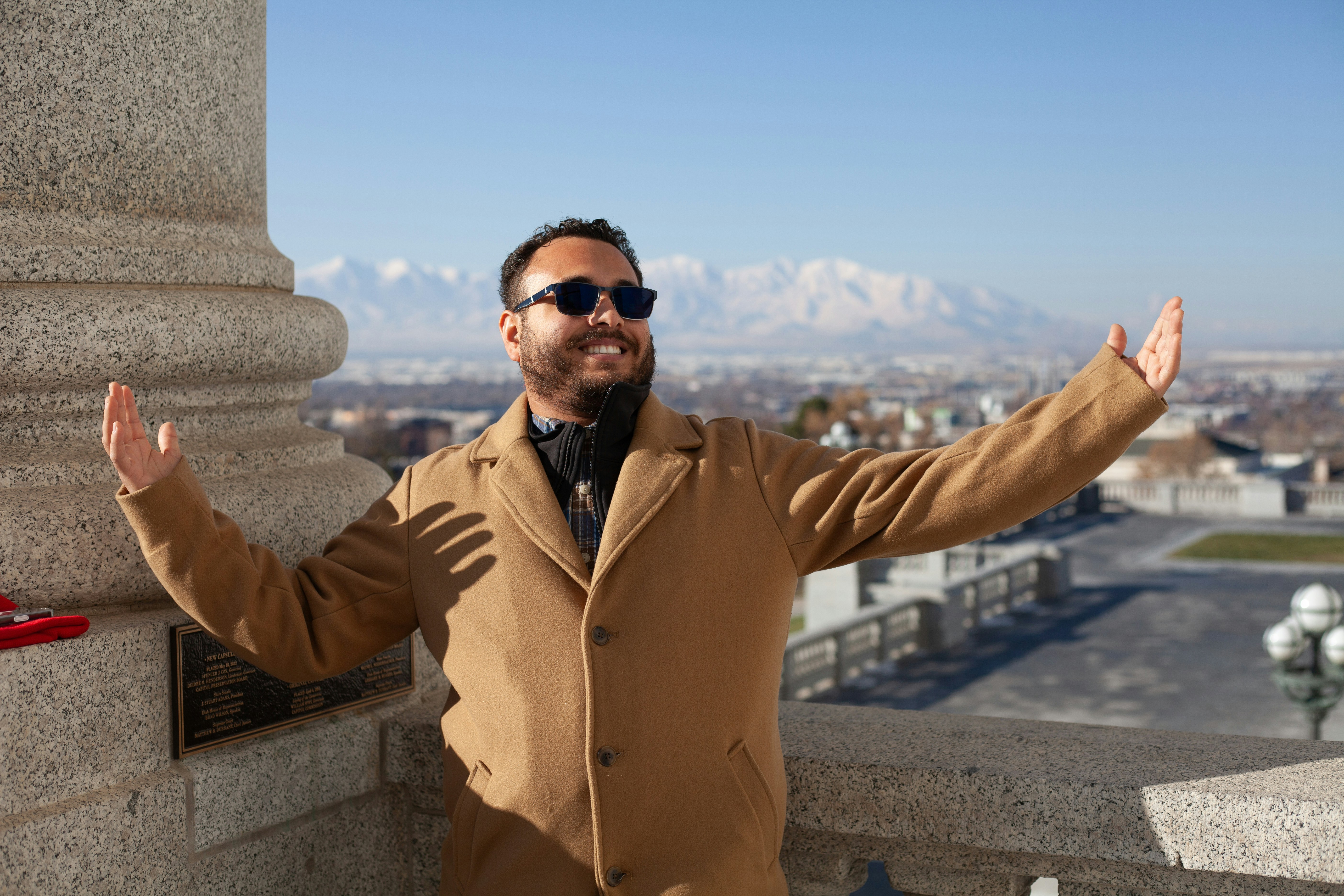 A man standing on a ledge with his hands in the air photo – Free ...