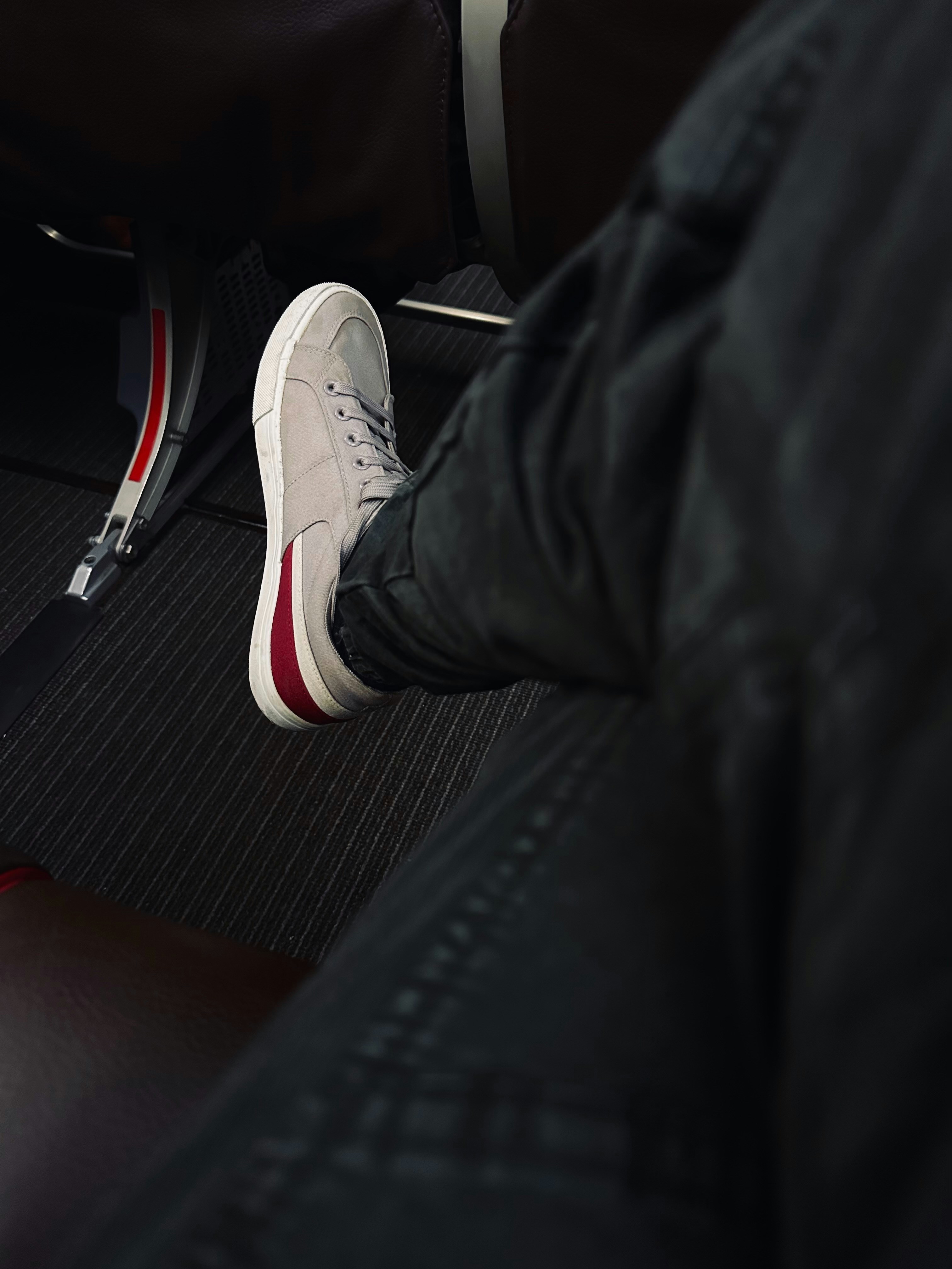 Paused in Transit: A White Sneaker Anchors a Quiet Plane Cabin