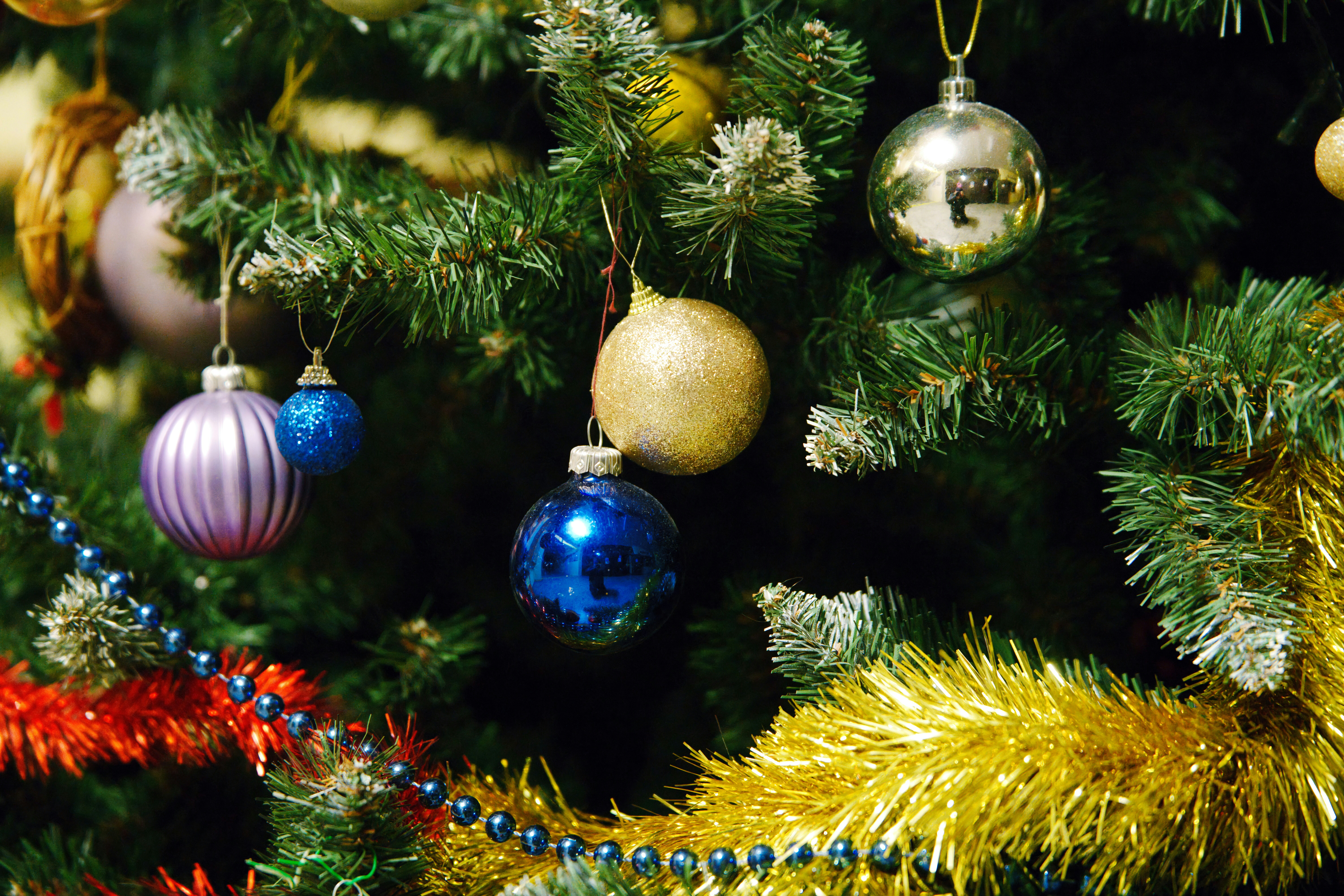 Blue Glass Sphere Anchors a Tinsel-Glow Christmas Tree