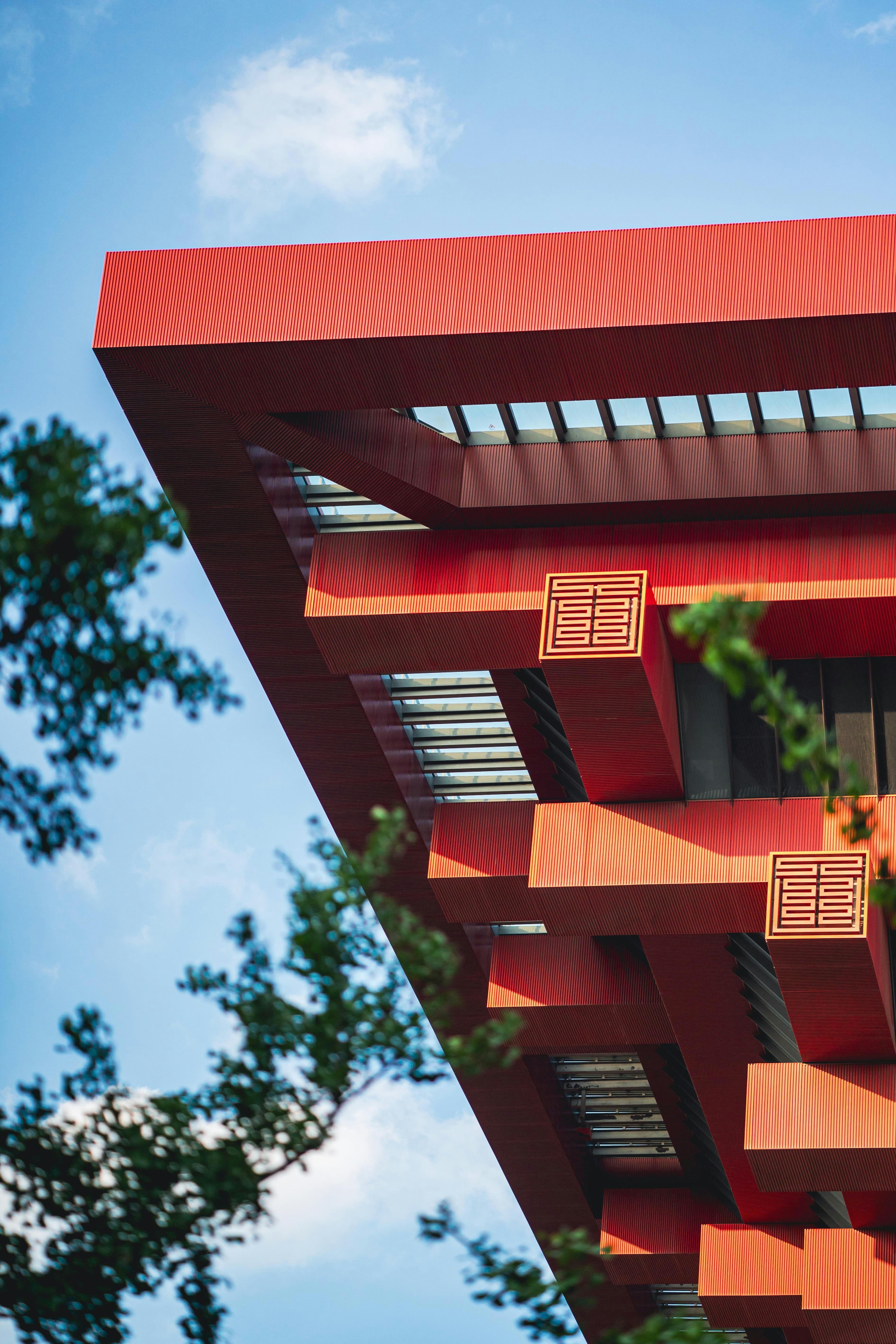 A tall red building with balconies on the top of it