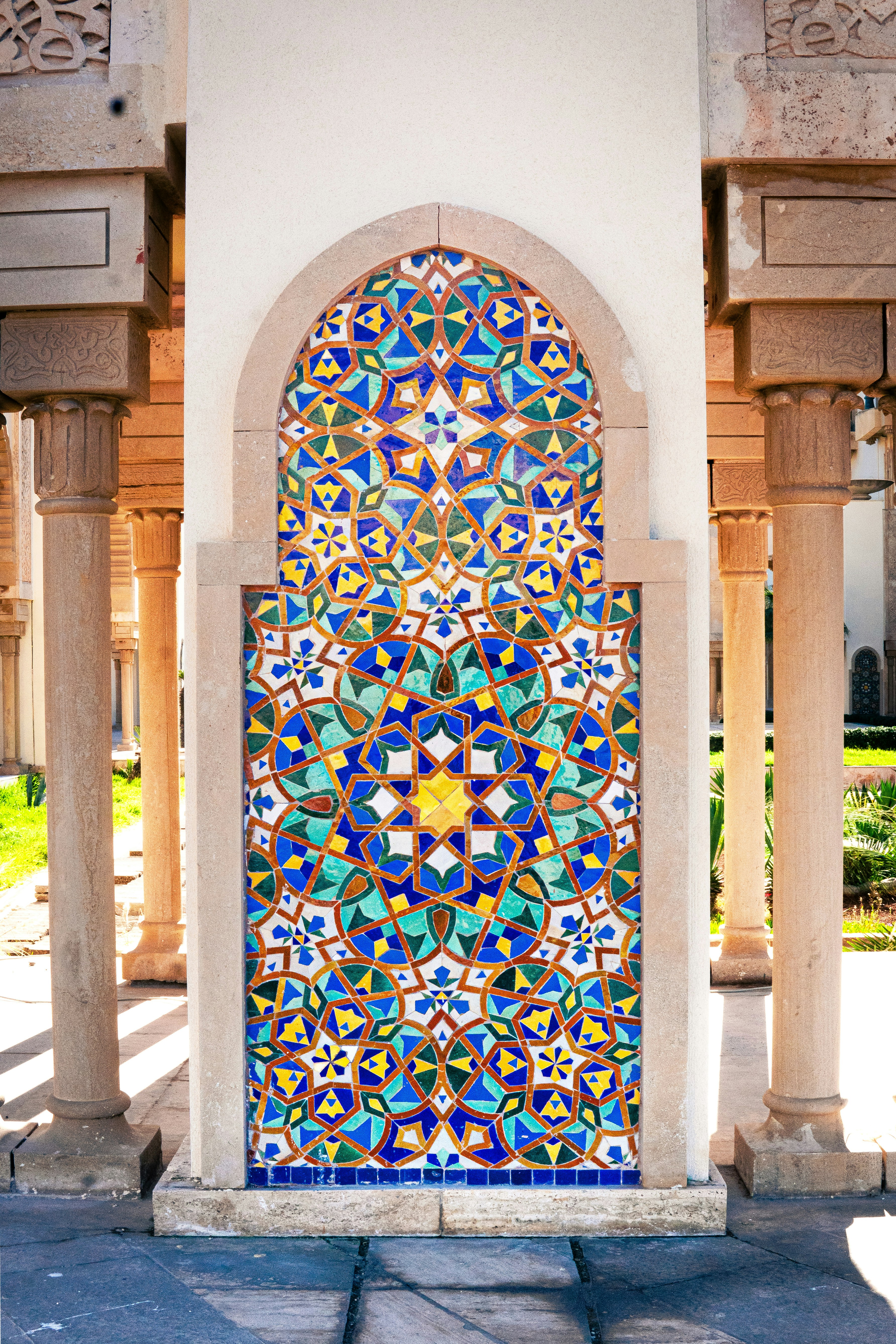 Geometric Sunlit Arch: A Mosaic Panel Framed by Colonnades
