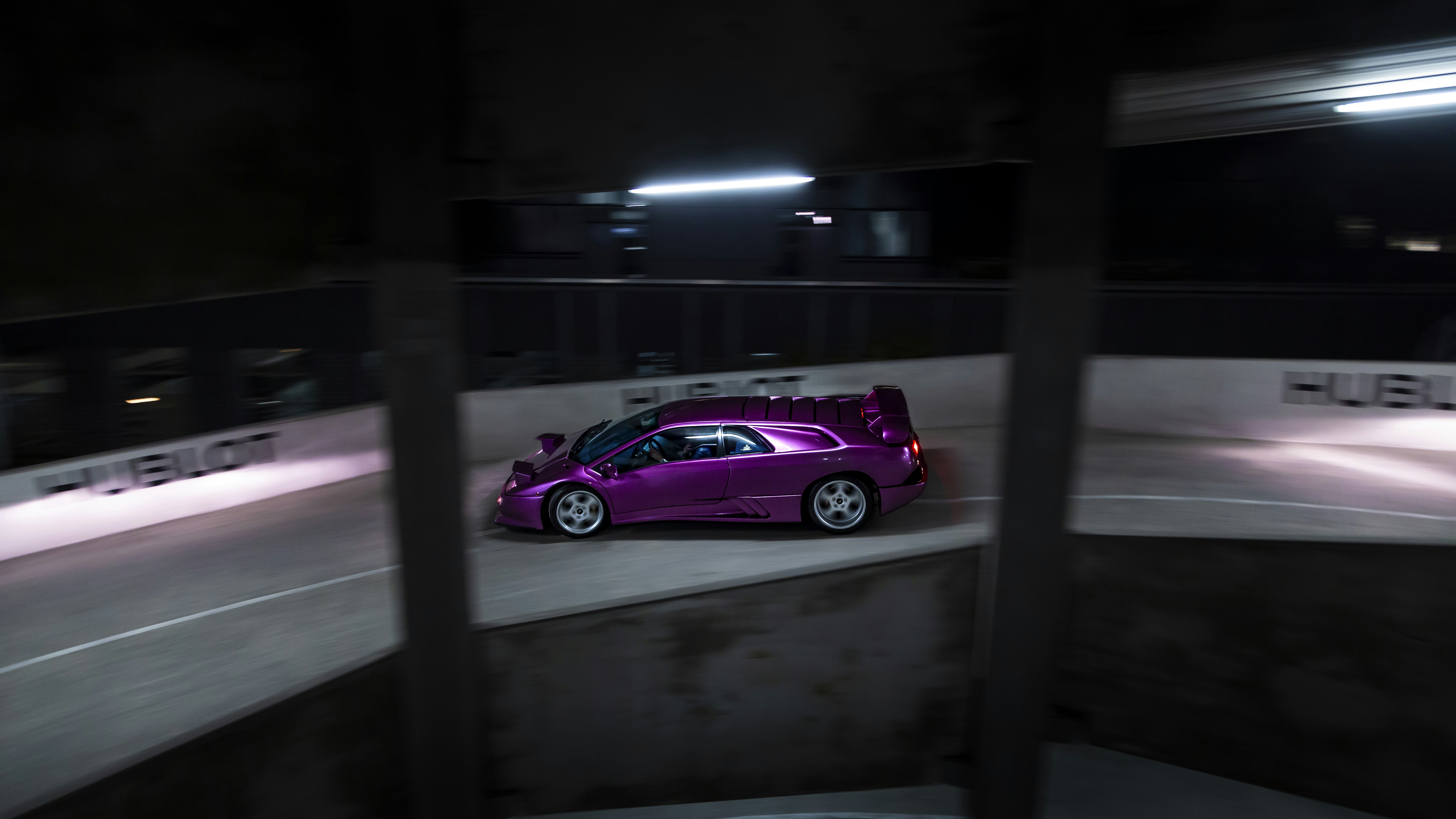 A purple car driving down a street at night photo – Free Wallpaper ...