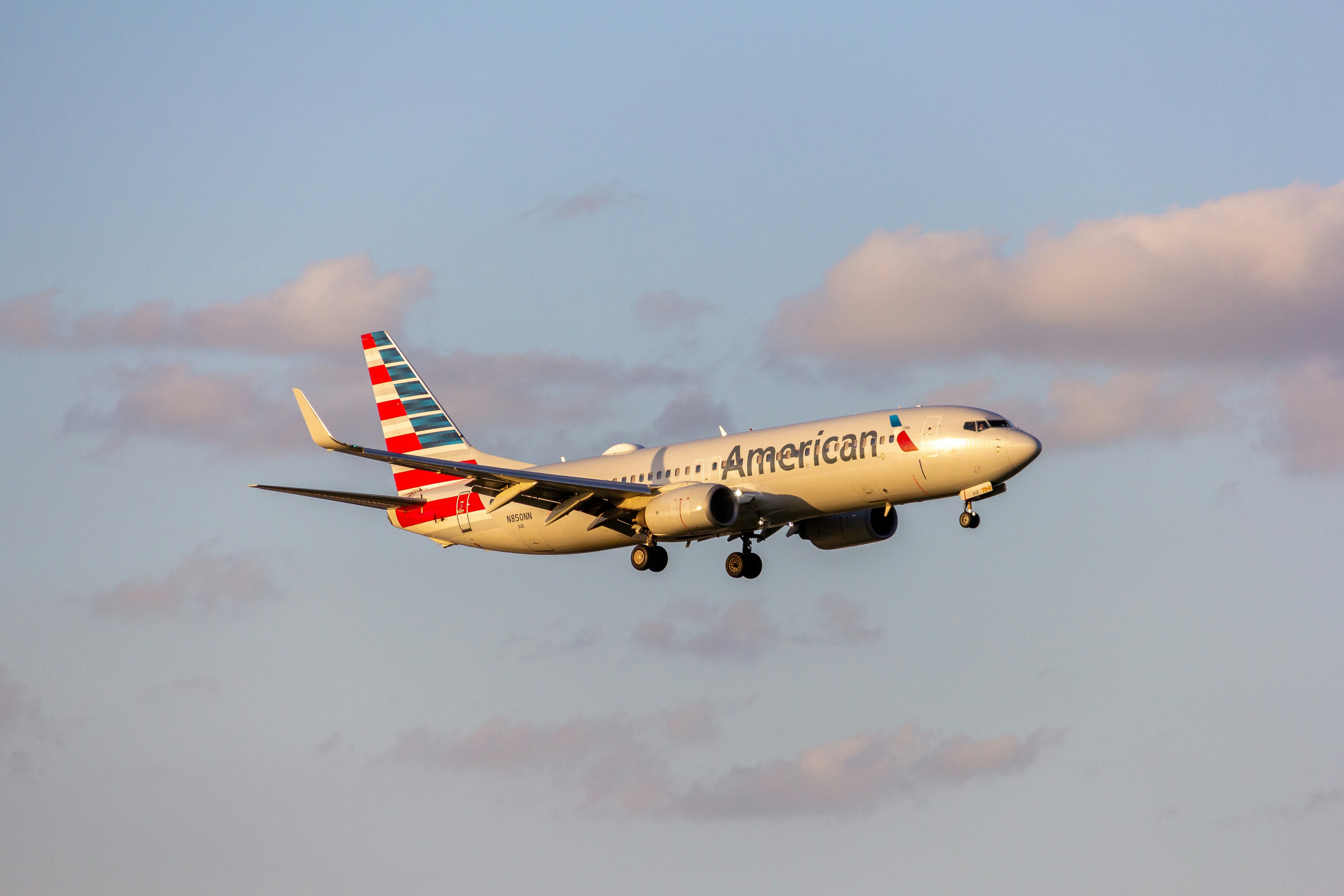 A large passenger jet flying through a blue sky photo – Free Dfw ...