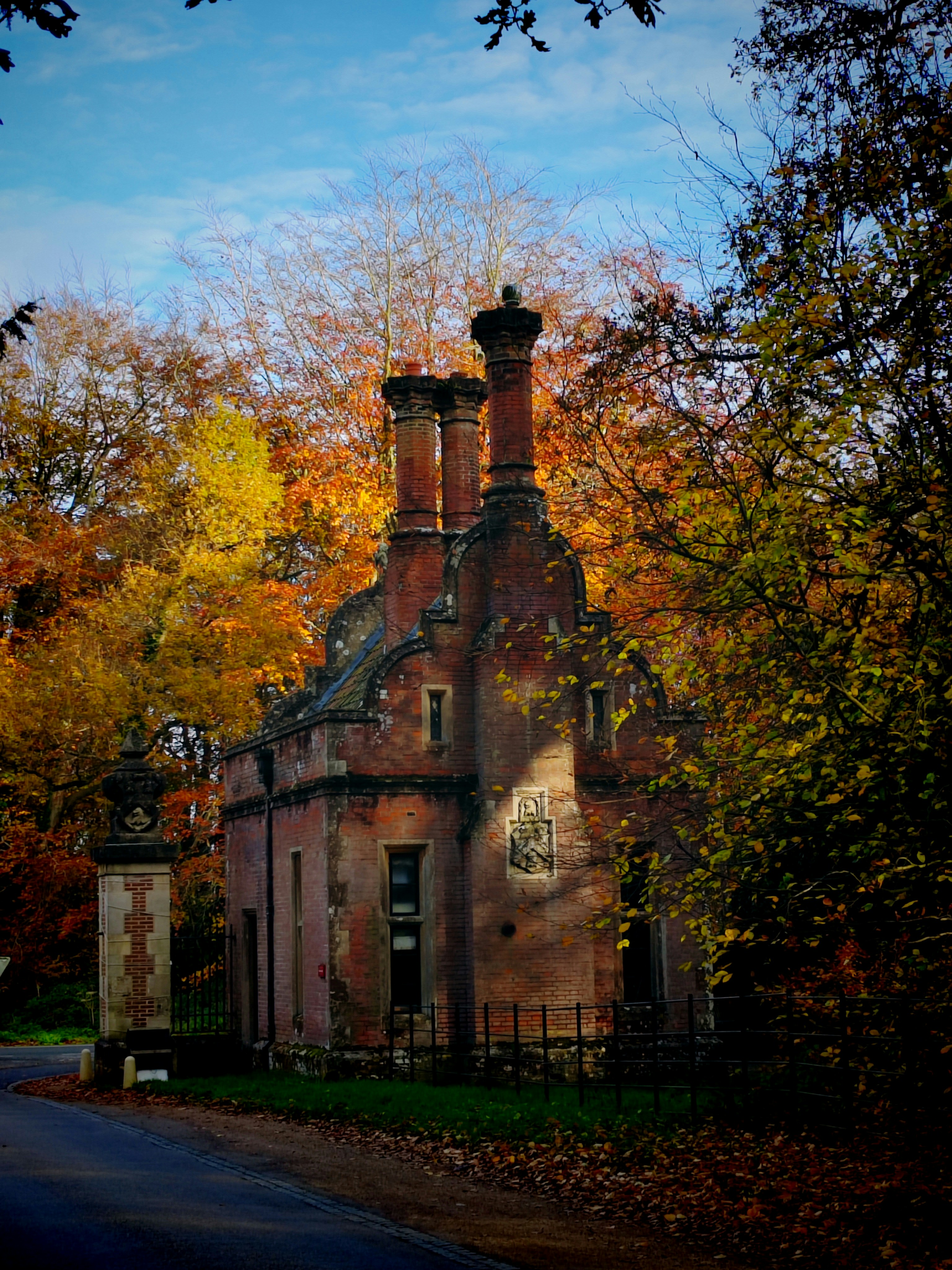 An old brick building surrounded by trees in the fall photo – Free ...