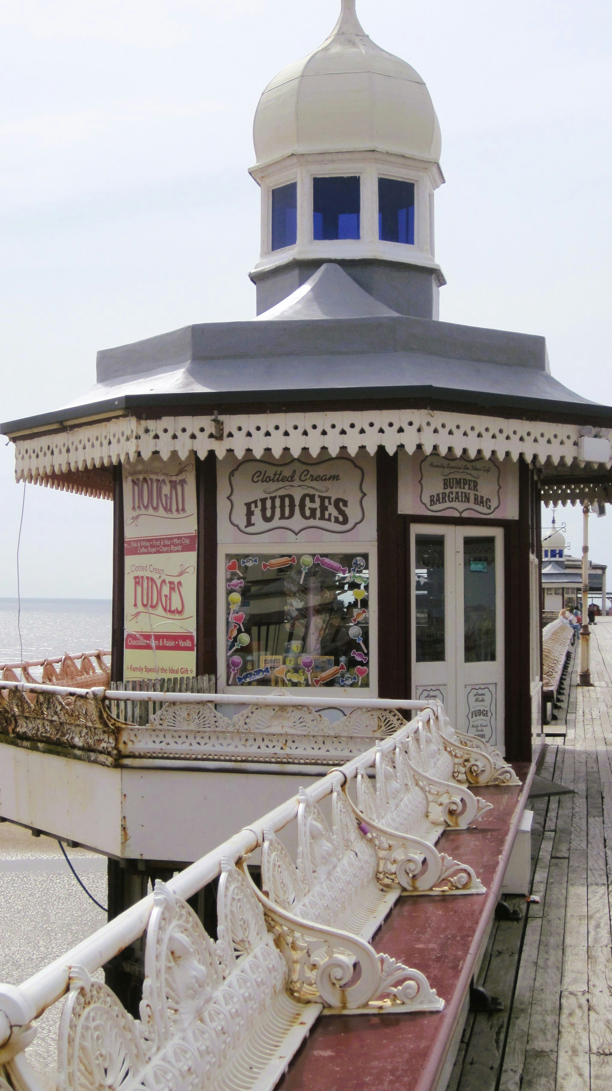A pier with a bench and a clock tower on top of it photo – Free ...