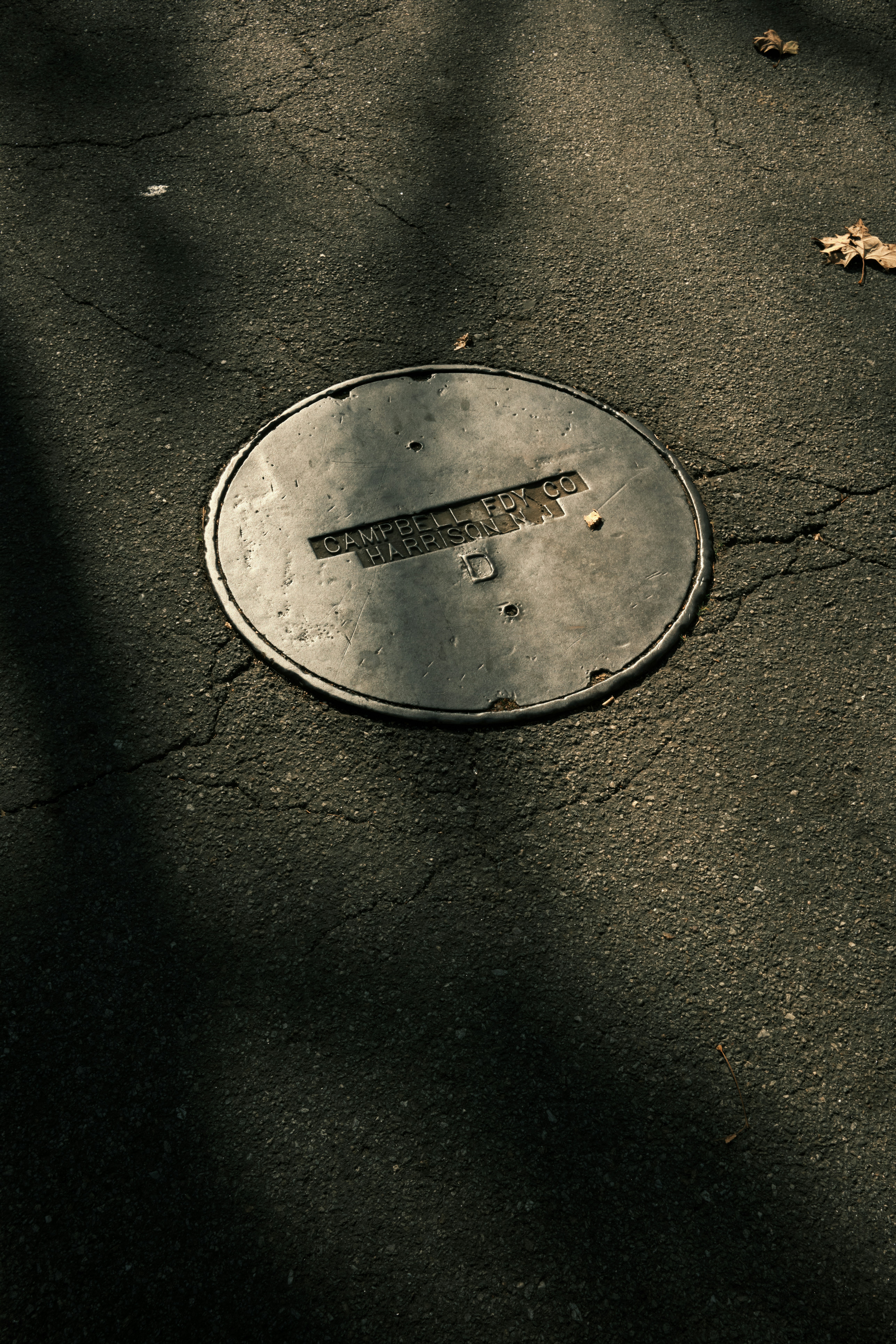 A manhole cover sitting on the side of a road photo – Free Hole Image ...