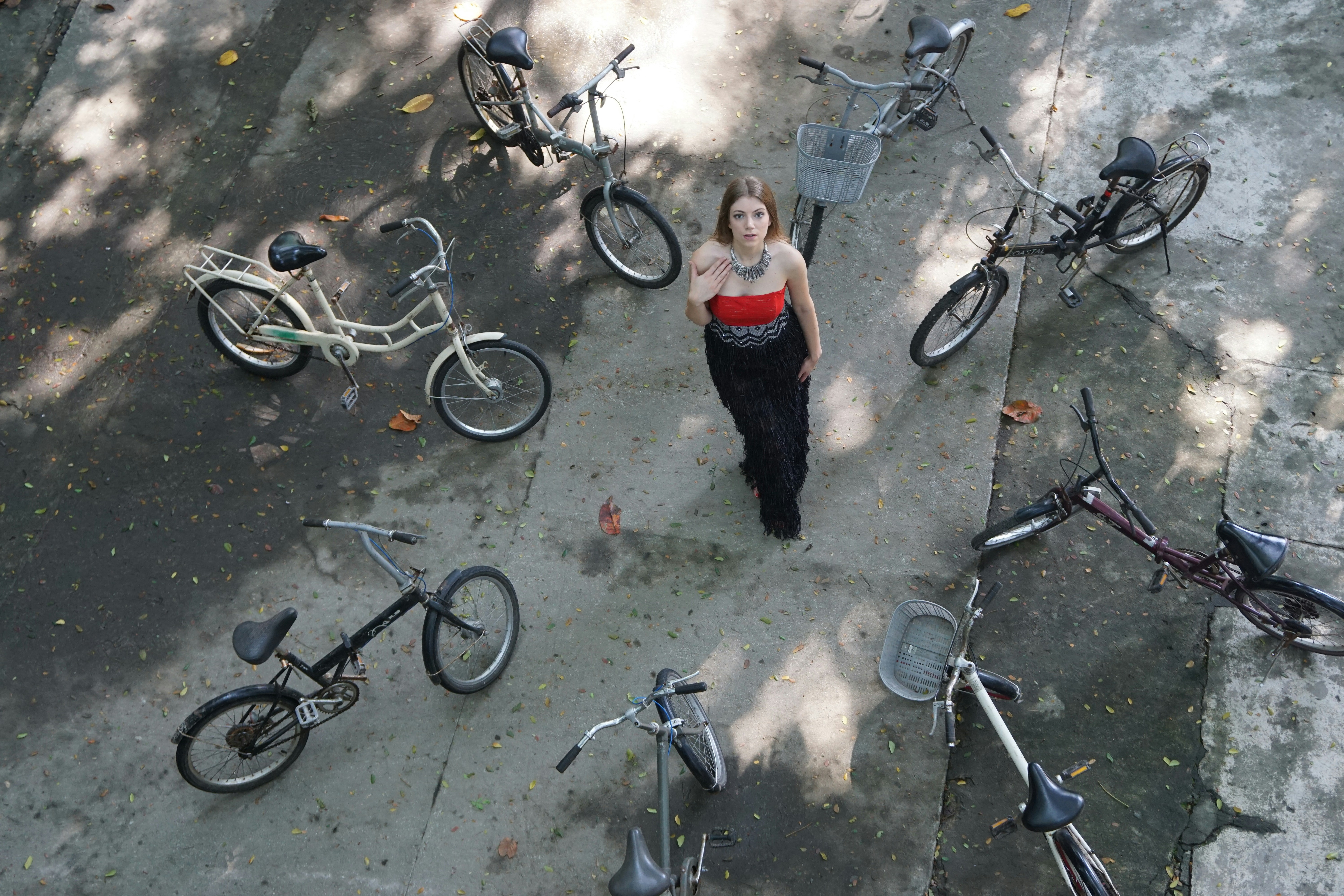 Center Stage Among the Bicycles: A solitary figure stands in a sunlit courtyard.