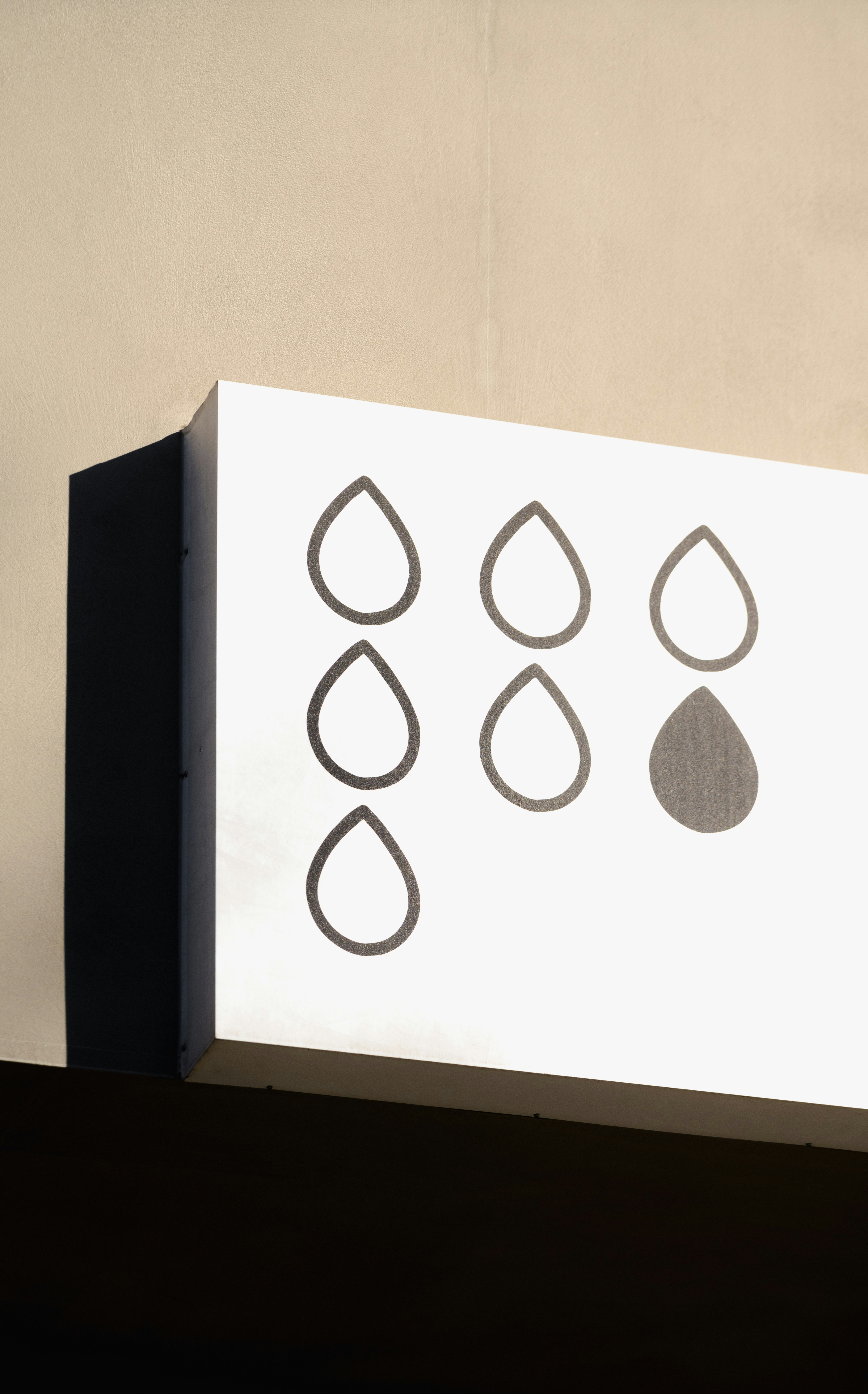 Teardrop Glyphs on a Sunlit Signboard