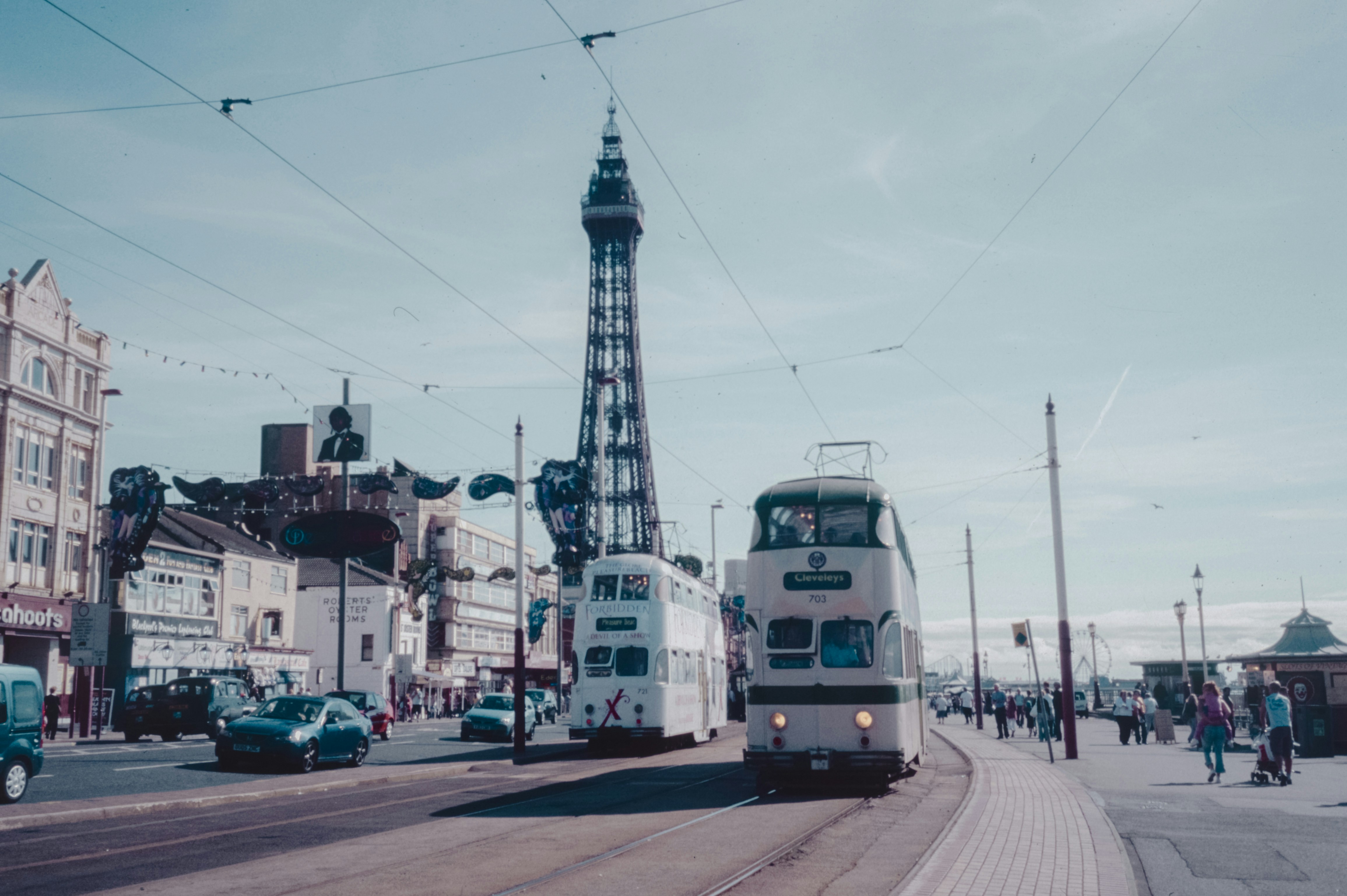 A double decker bus driving down a street next to tall buildings photo ...